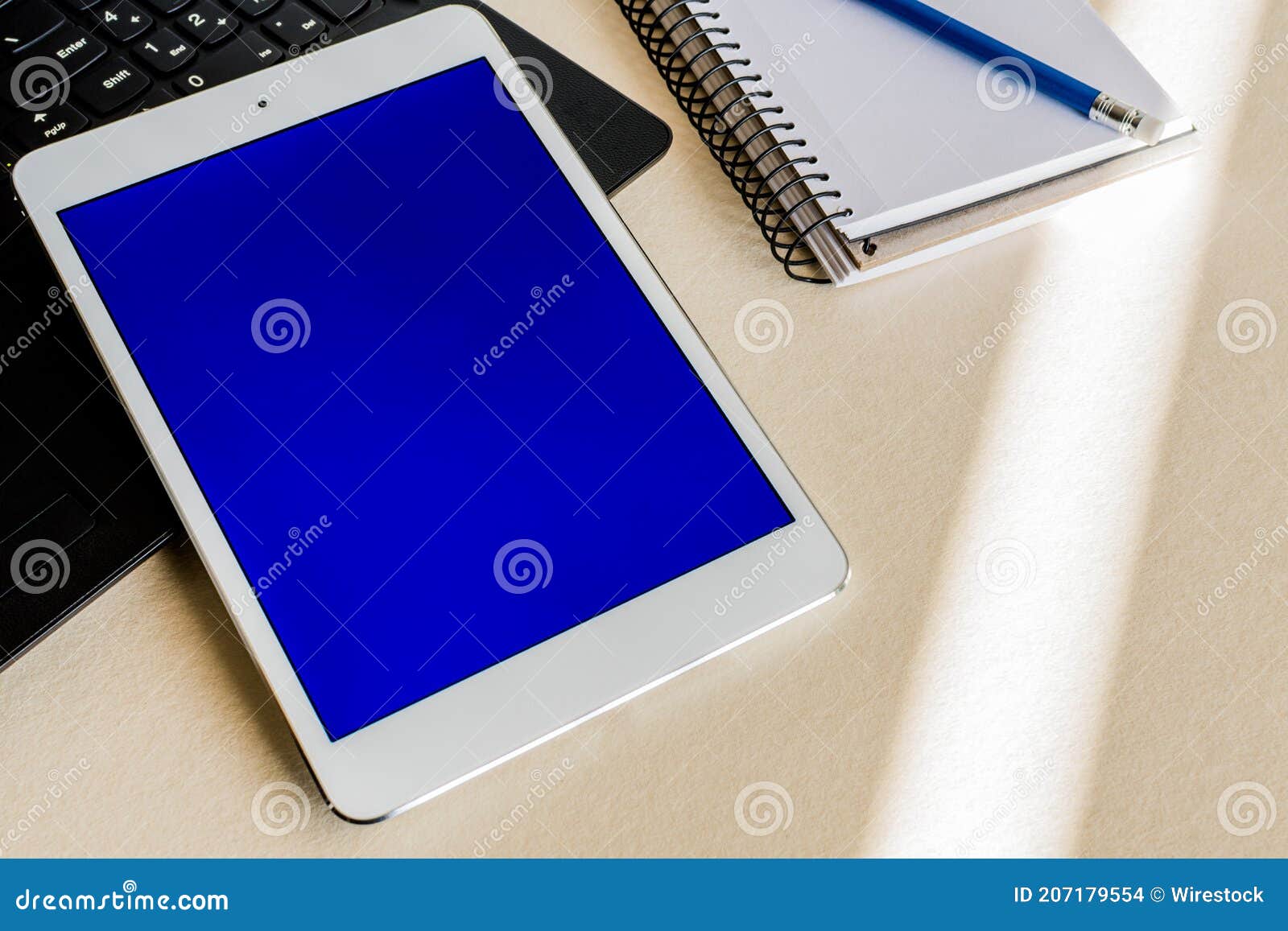 Tablet with Blue Screen on the Keyboard of a Laptop on a Desk ...