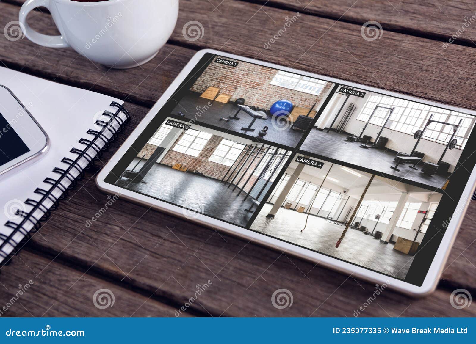 Tablet with View of Gym from Security Cameras on Screen Lying on Wooden ...