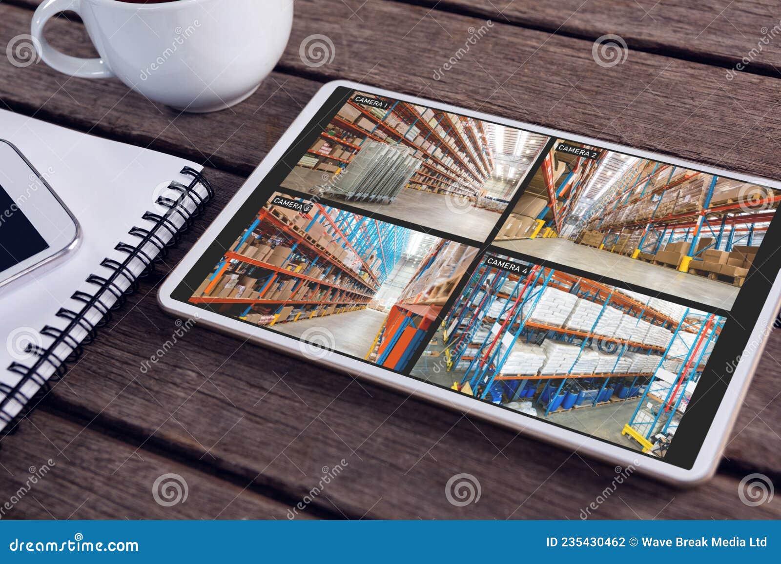 Tablet with Views of Warehouse from Security Cameras on Screen Lying on ...