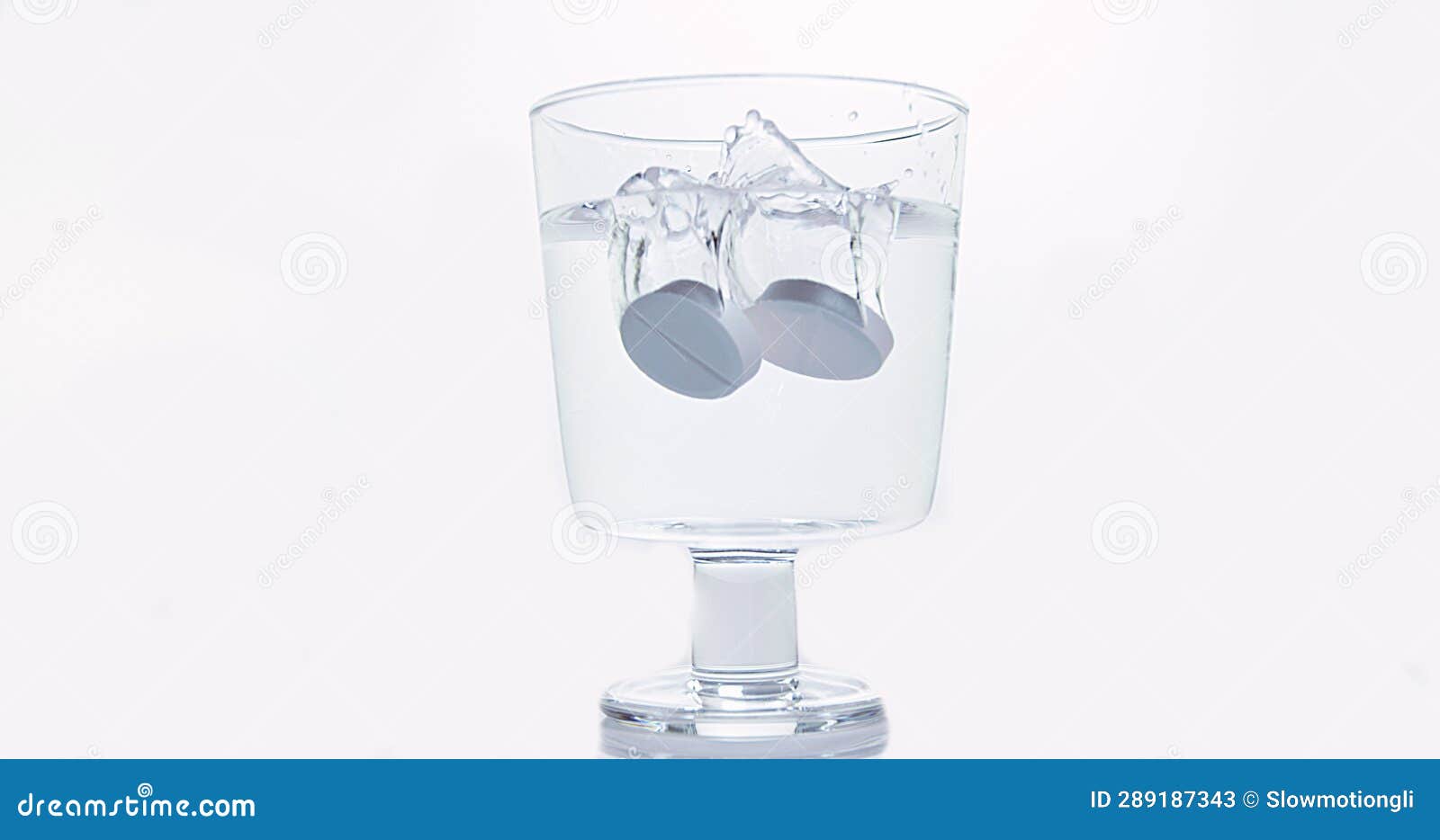 Tablets Falling and Dissolving into a Glass of Water Against White ...