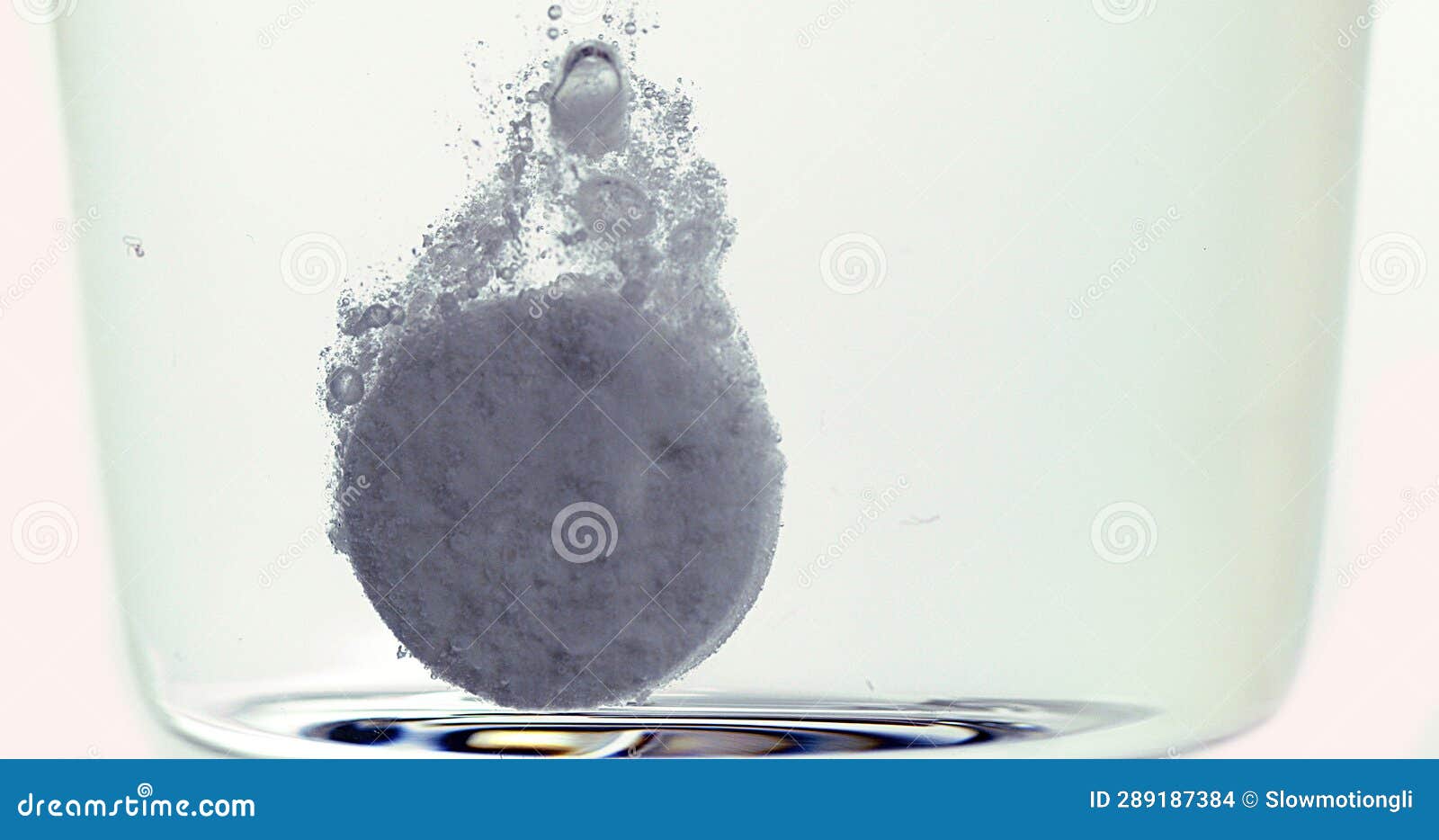 Tablets Falling and Dissolving into a Glass of Water Against White ...