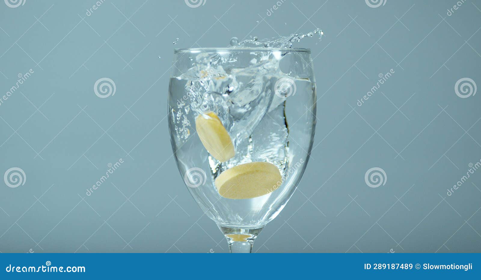 Tablets Falling and Dissolving into a Glass of Water Against White ...