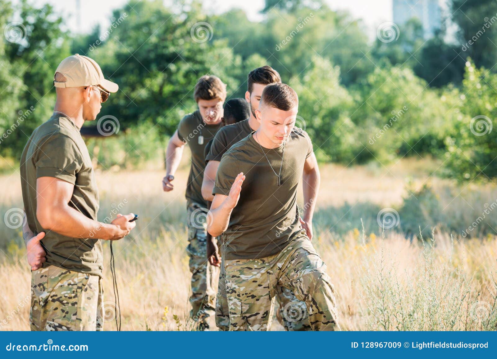 Tactical Instructor with Stop Watch Examining Multiracial Soldiers ...