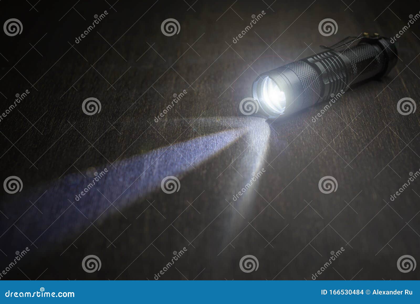 Tactical Waterproof Flashlight. LED Flashlight Shines on the Table in ...
