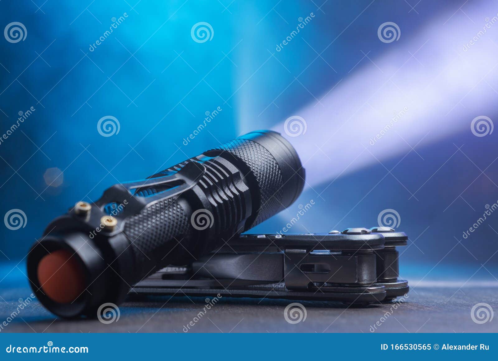 Tactical Waterproof Flashlight. LED Flashlight Shines on the Table in ...