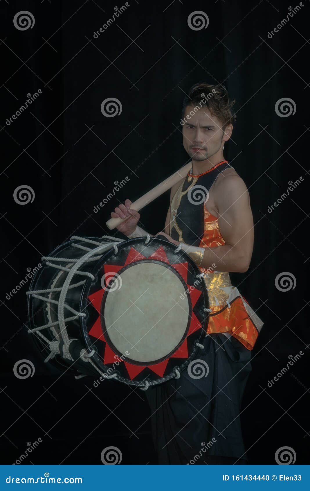 Taiko Drummer In A Wig And A Demon Mask On Stage With Drumstick In His ...