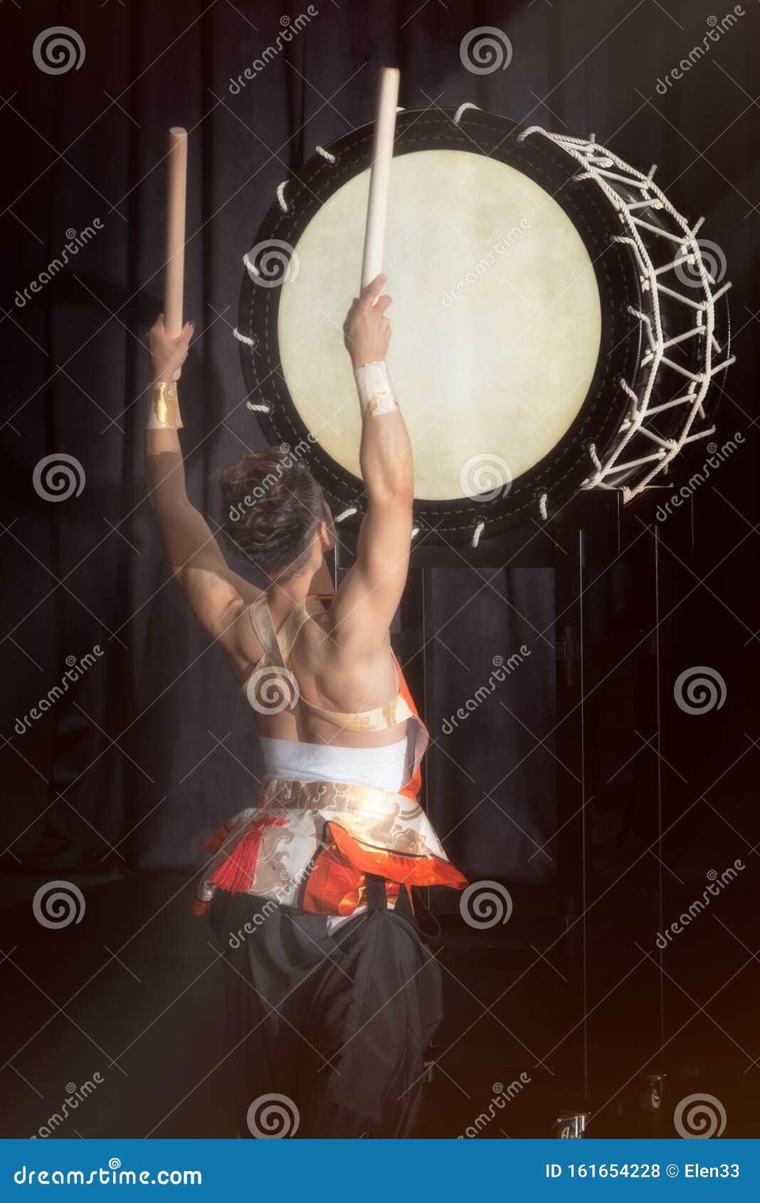 Taiko Drummer In A Wig And A Demon Mask On Stage With Drumstick In His ...