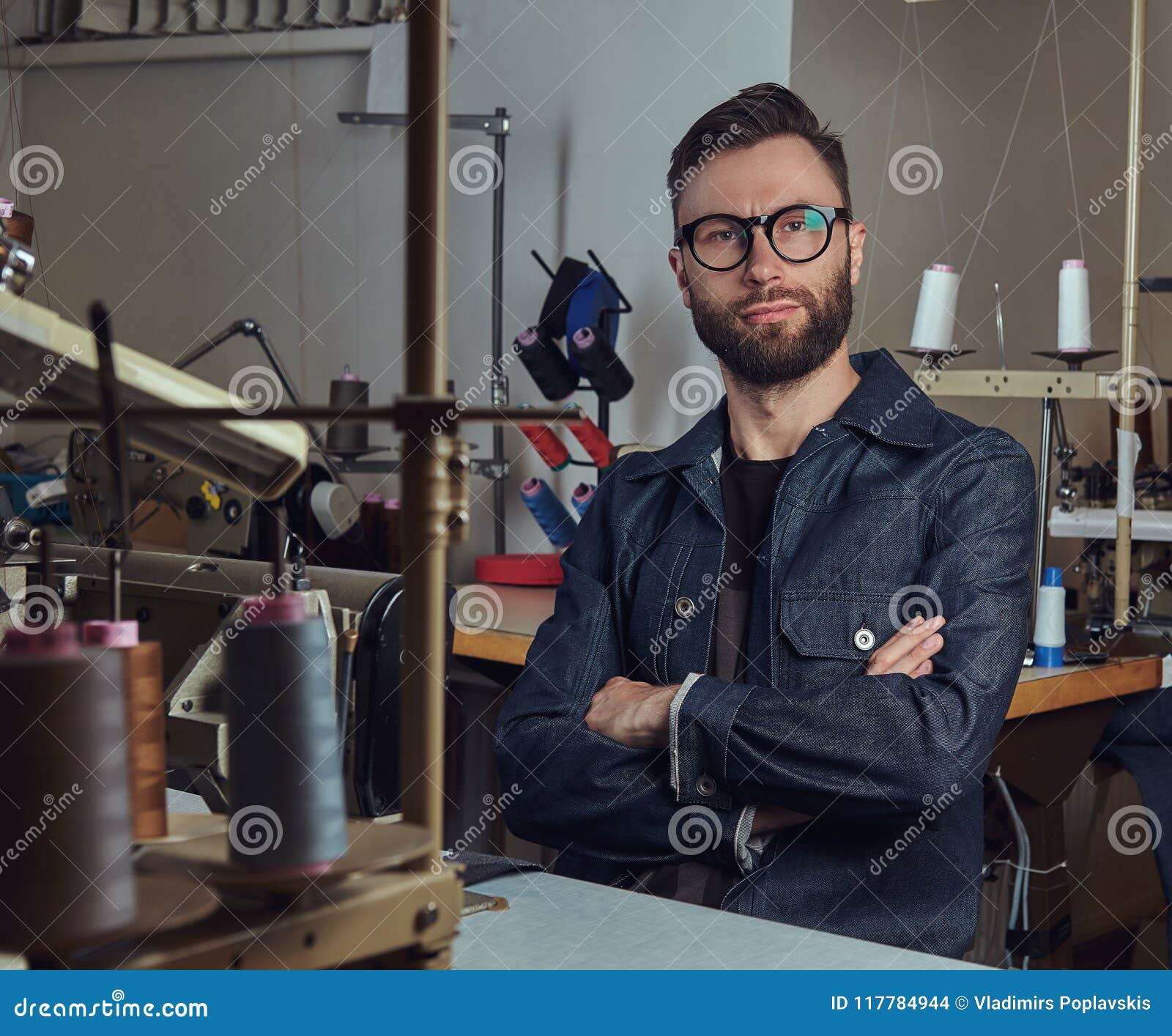 Tailor Crossed Arms Sitting at Table with Sewing Machine, Looking at a ...