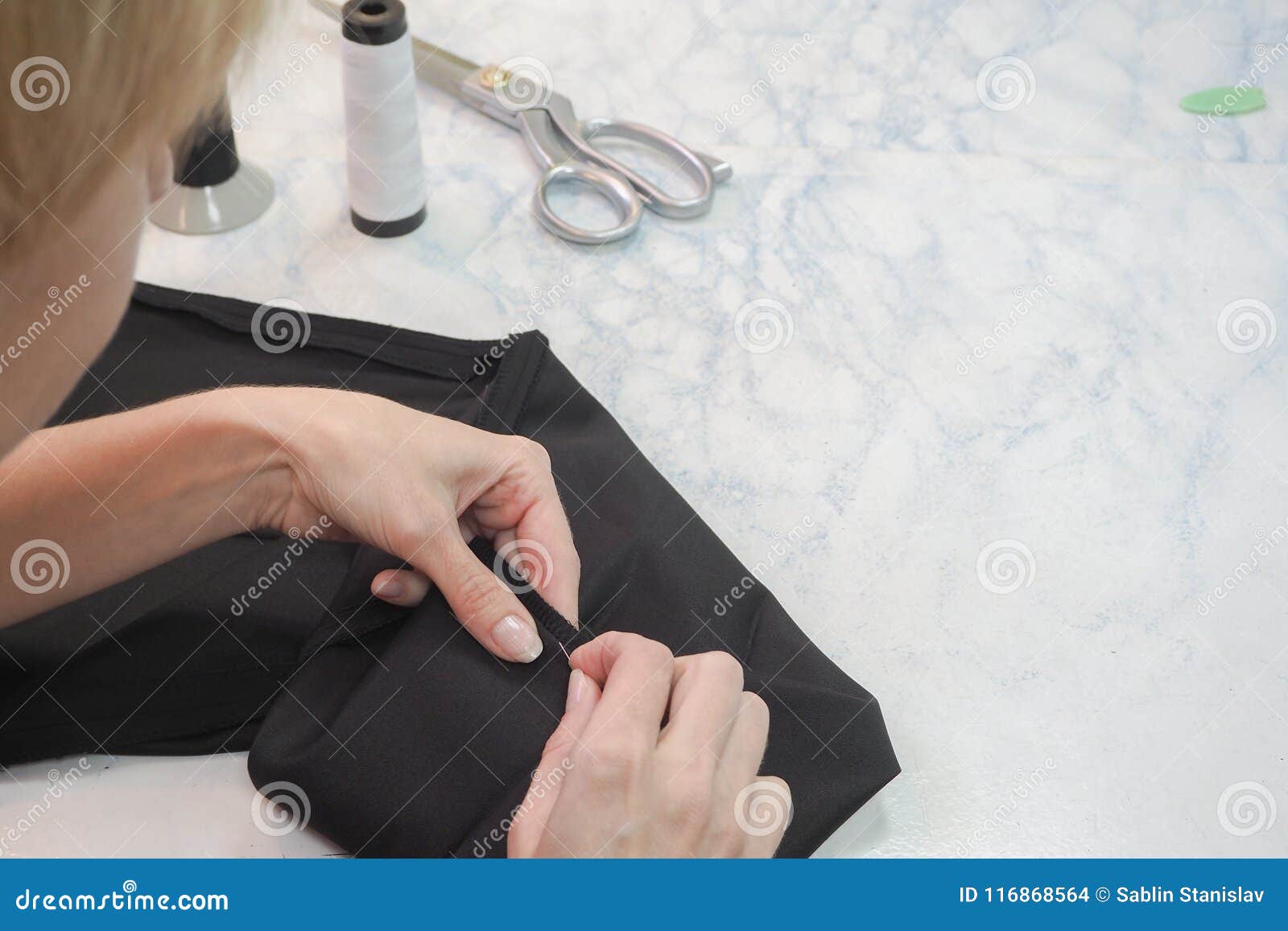 Tailor`s Business. the Hem of the Pants Manually with a Needle and ...
