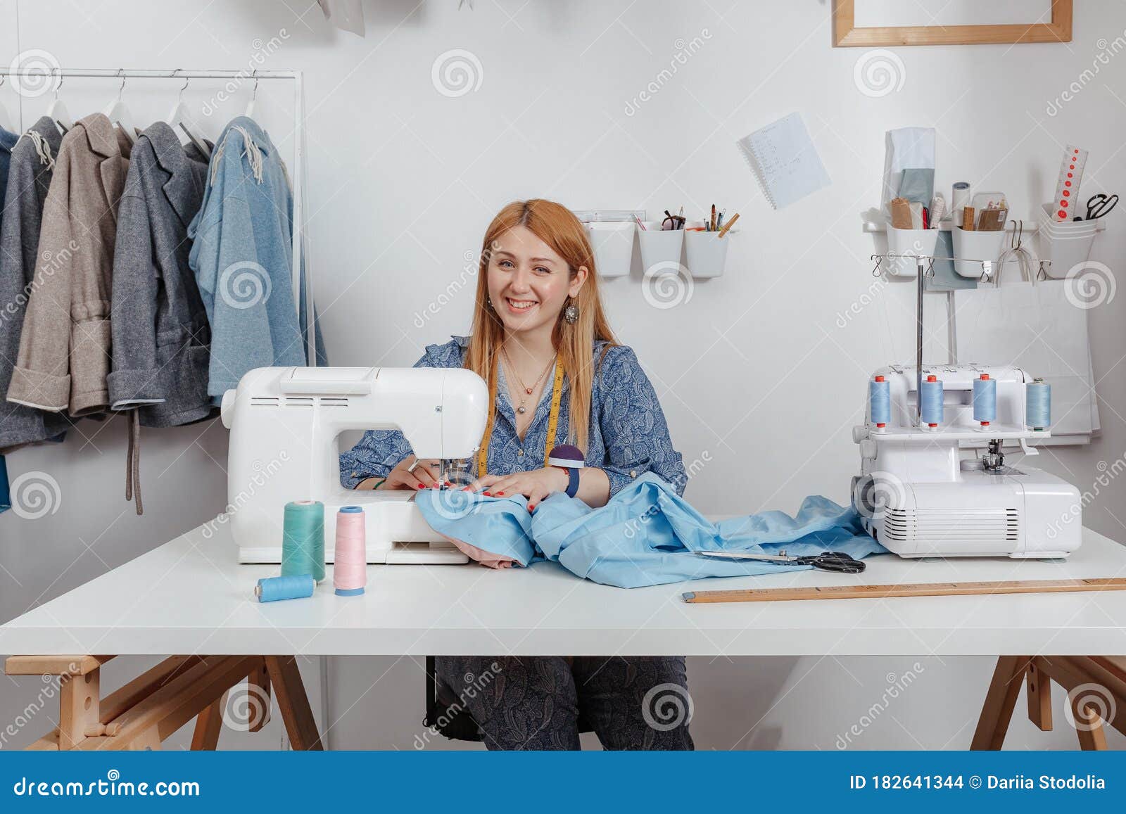 Tailor Smiles In Her Studio While Working On A Sewing Machine. Fashion ...