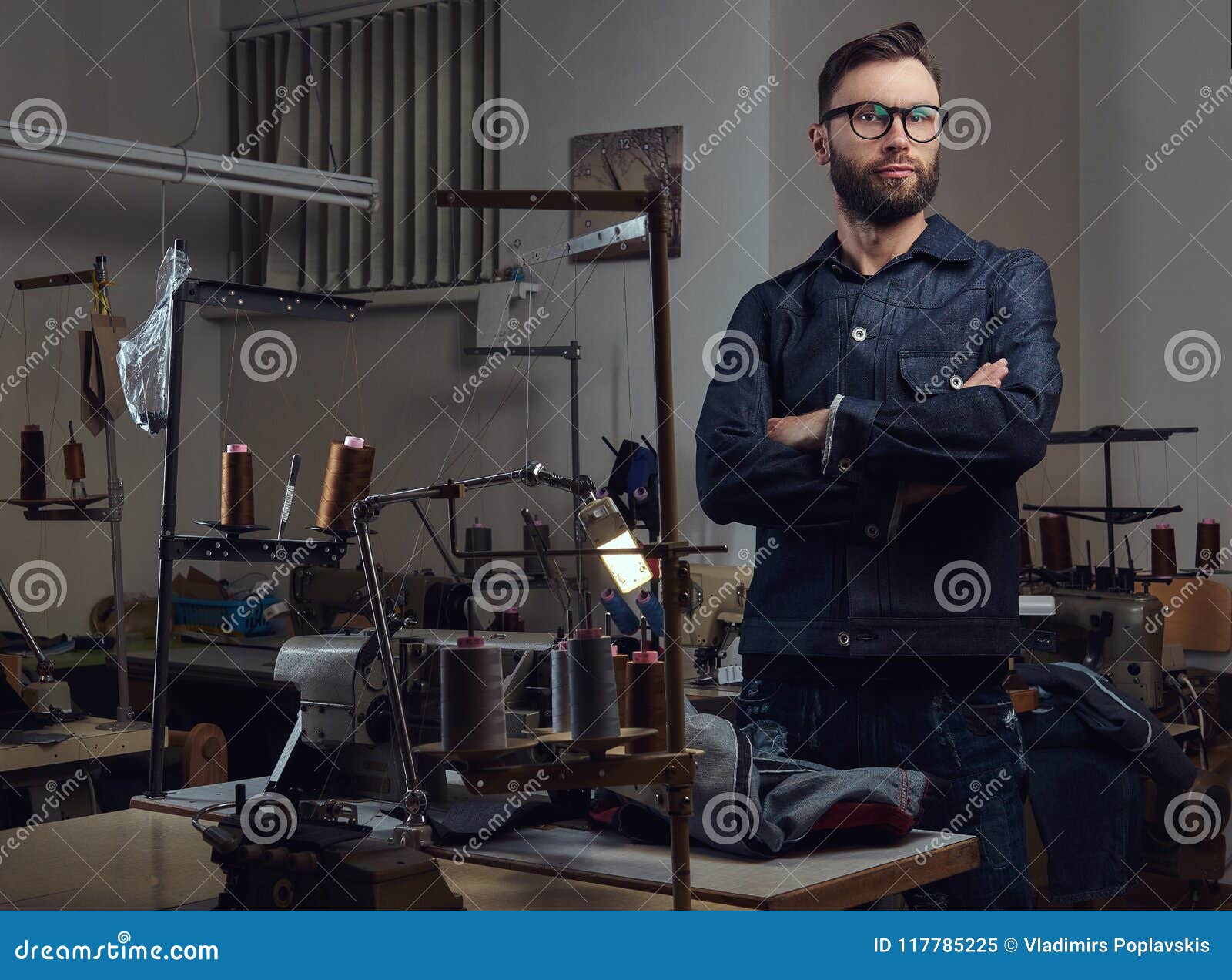 Tailor Standing Near Table with Sewing Machine and Looking at a Camera ...