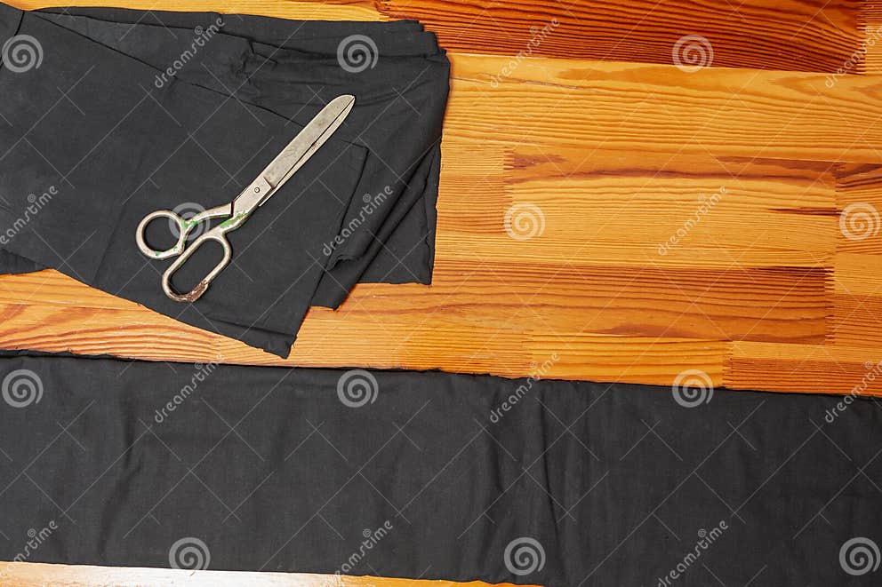Tailoring Concepts. Cutting Textile Cloth at Work Table with Old Rusty Scissors and Black Fabric ...