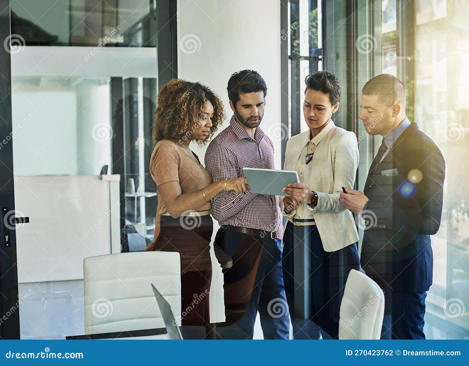 Taking a Closer Look. a Group of Colleagues Using a Tablet while ...