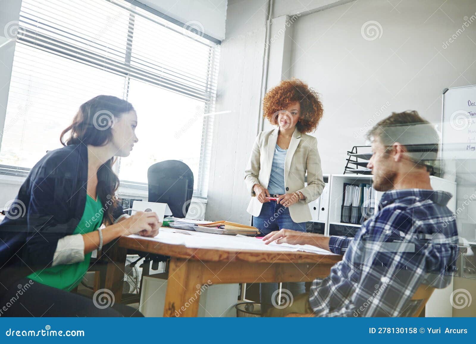 Taking a Look at the Paperwork. Three Colleagues Discussing Business in ...