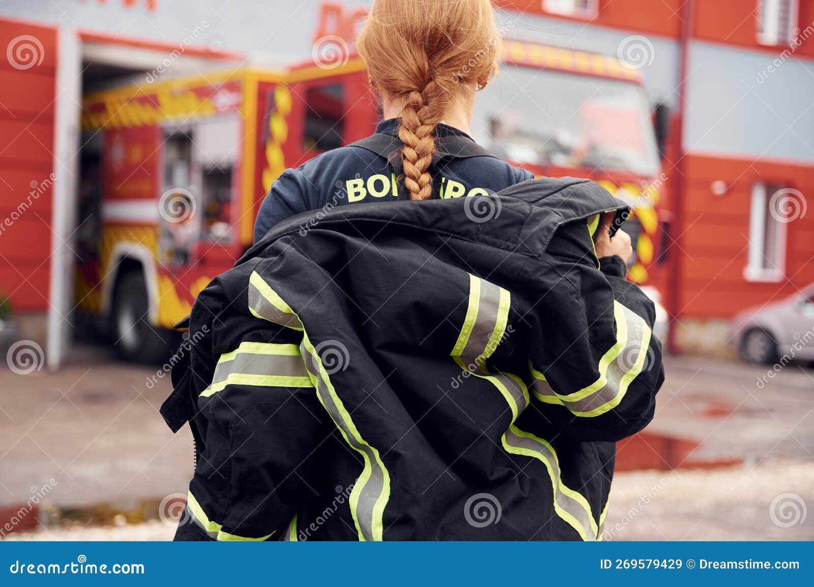 Taking Off the Protective Clothes. Woman Firefighter in Uniform is at ...