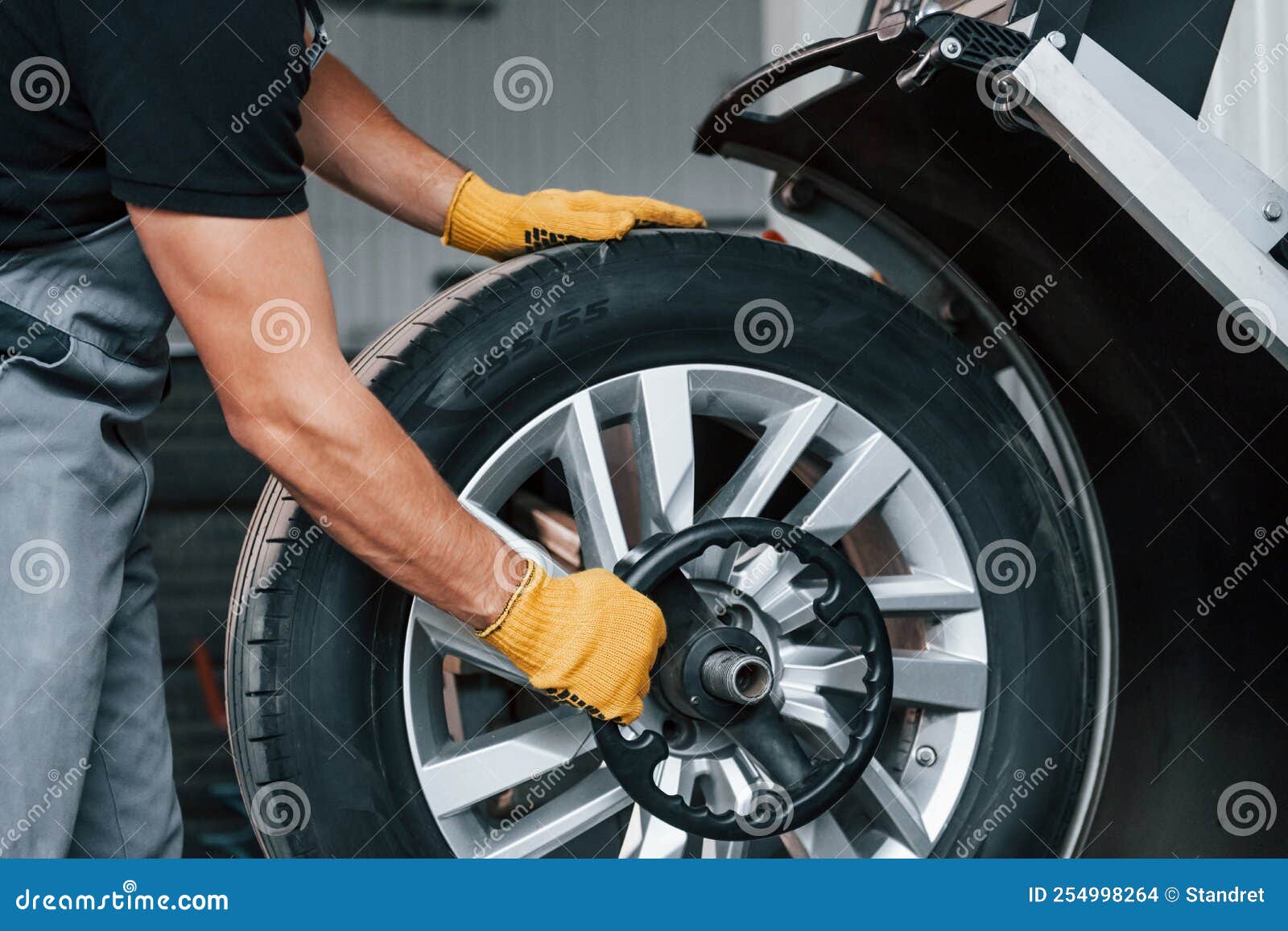 Taking the Wheel. Man in Uniform is Working in the Auto Service Stock ...