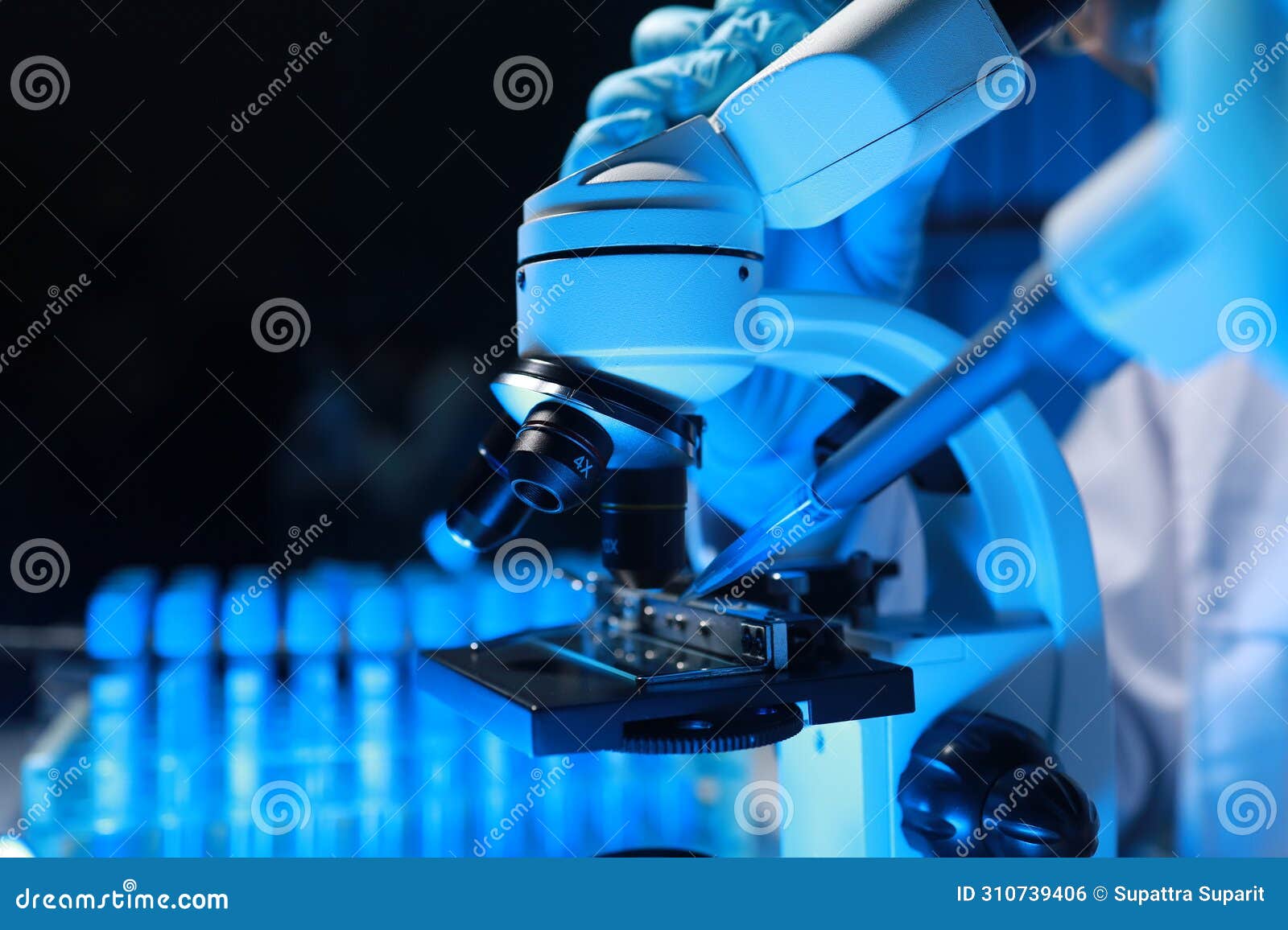 A Talented Scientist Sits In His Lab While Using A Microscope To Look ...