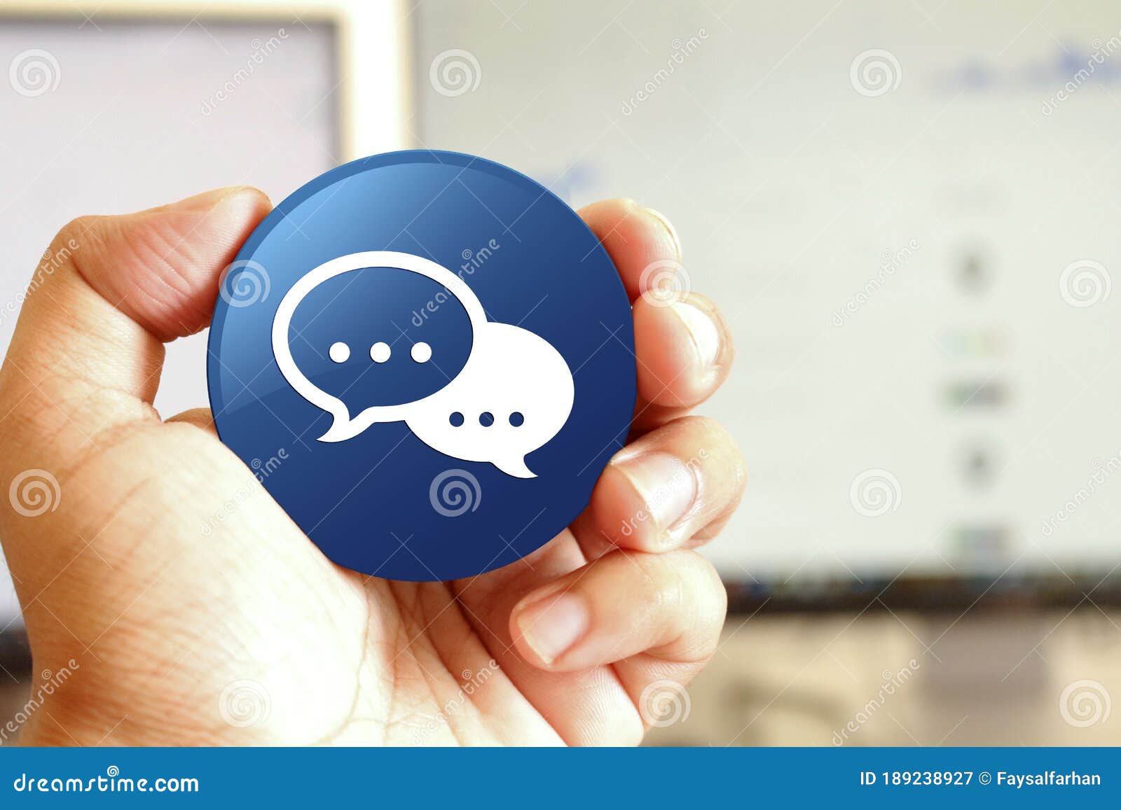 Talk Bubble Icon Blue Round Button Holding by Hand Infront of Workspace ...