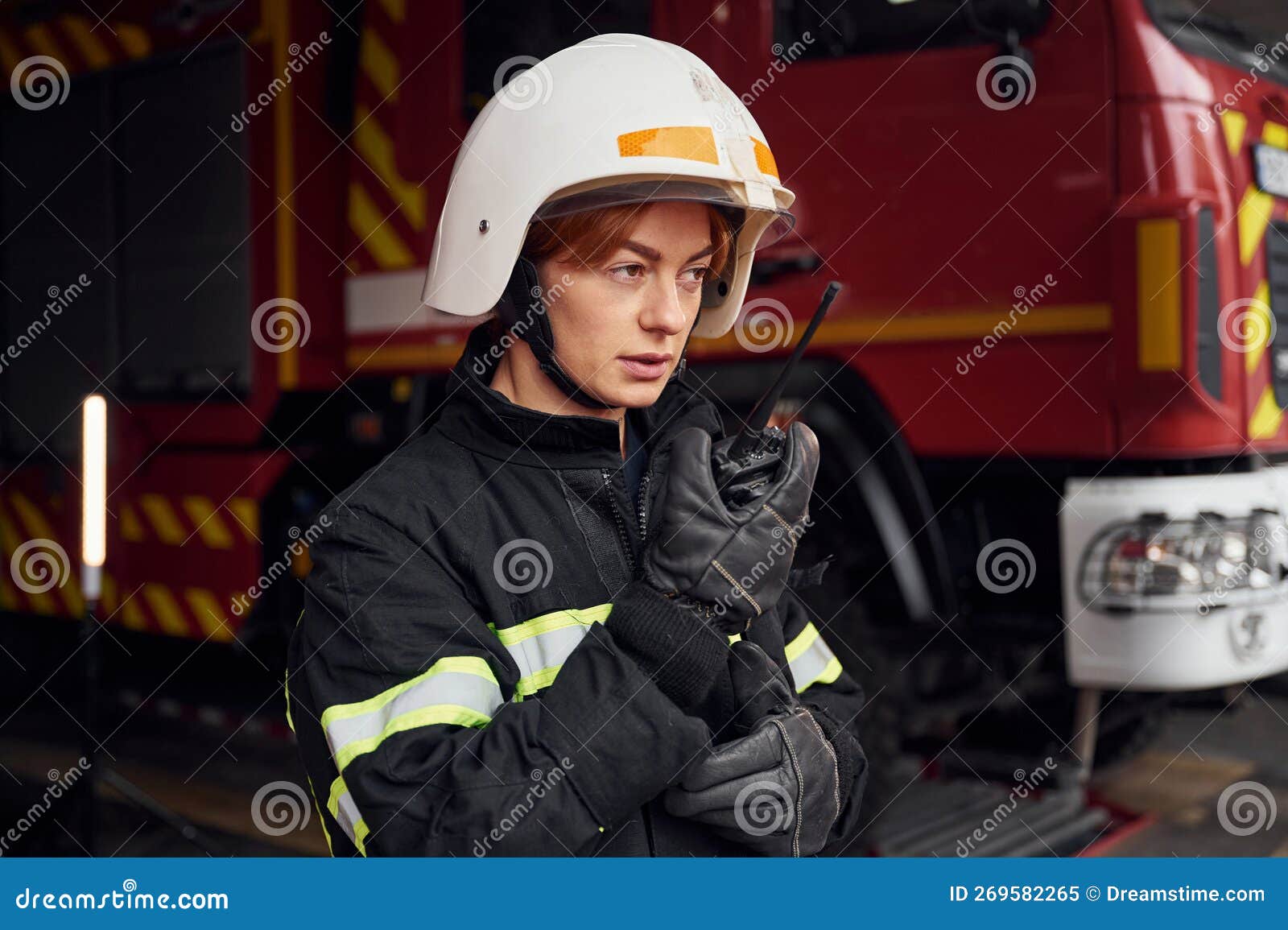 Talking by Using Radio Transmitter. Woman Firefighter in Uniform is at ...