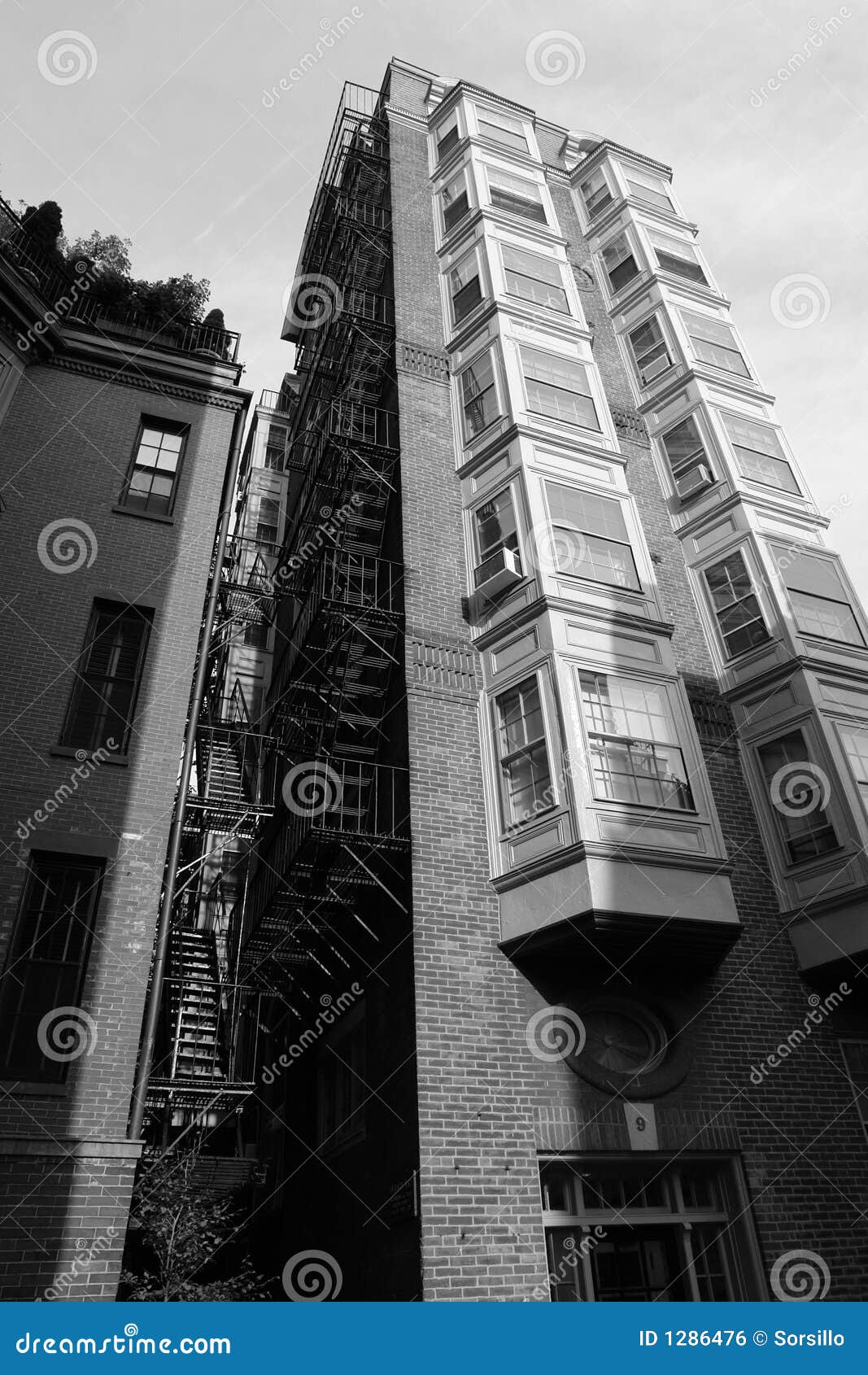 Tall Building with Fire Escape and Bay Windows Stock Photo - Image of ...