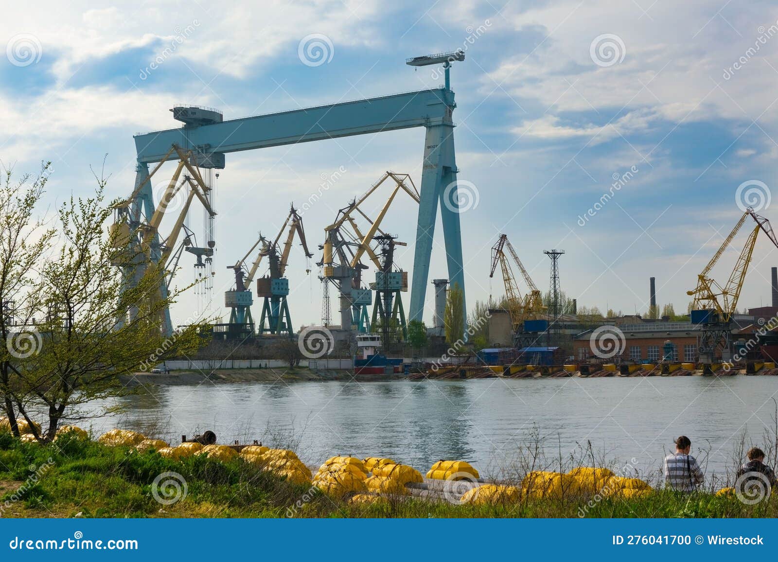 Tall Cranes Visible in the Background in a Construction Side by a Lake ...