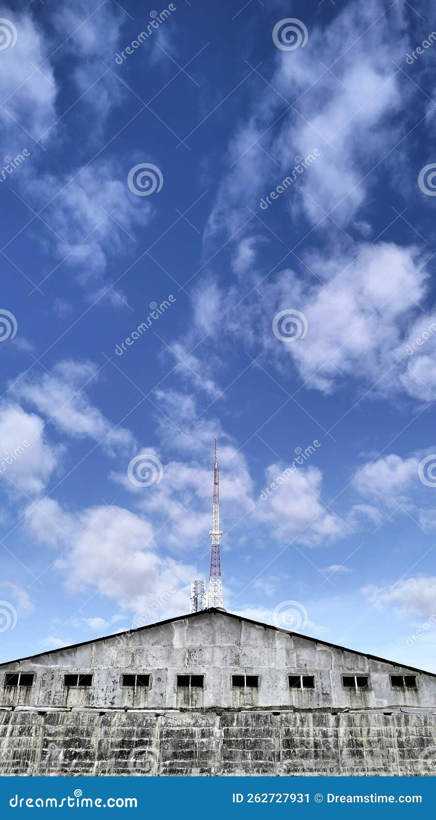 A Tall Electric Pole Behind a Large Building Stock Image - Image of ...
