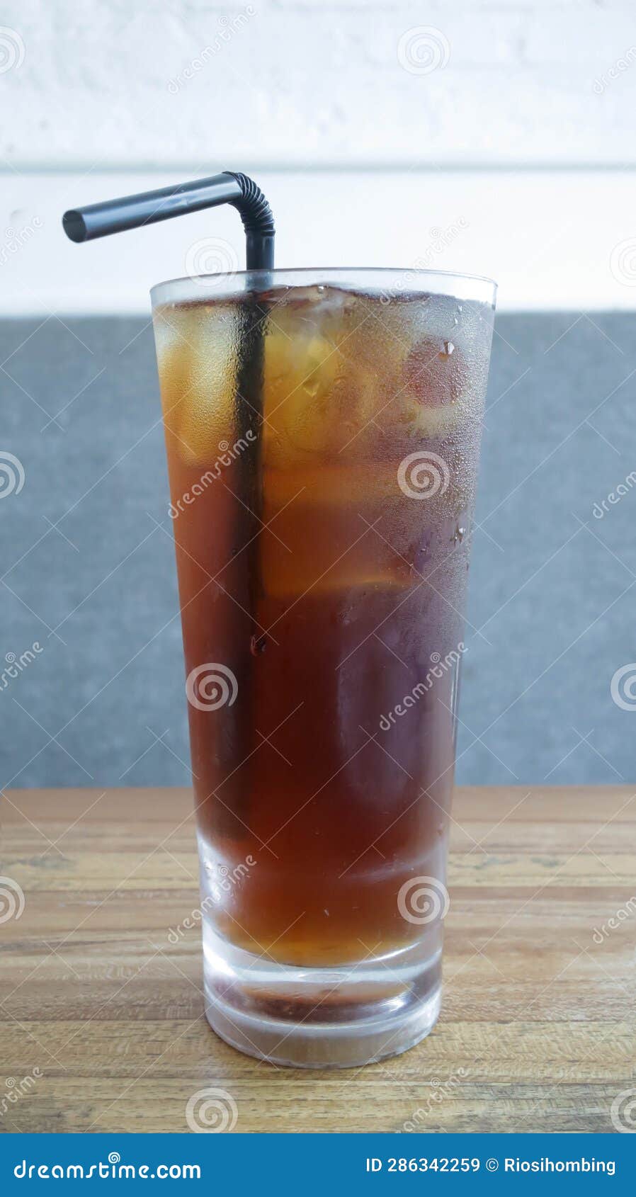 A Tall Glass of Ice Tea with a Straw on the Table Stock Image - Image ...