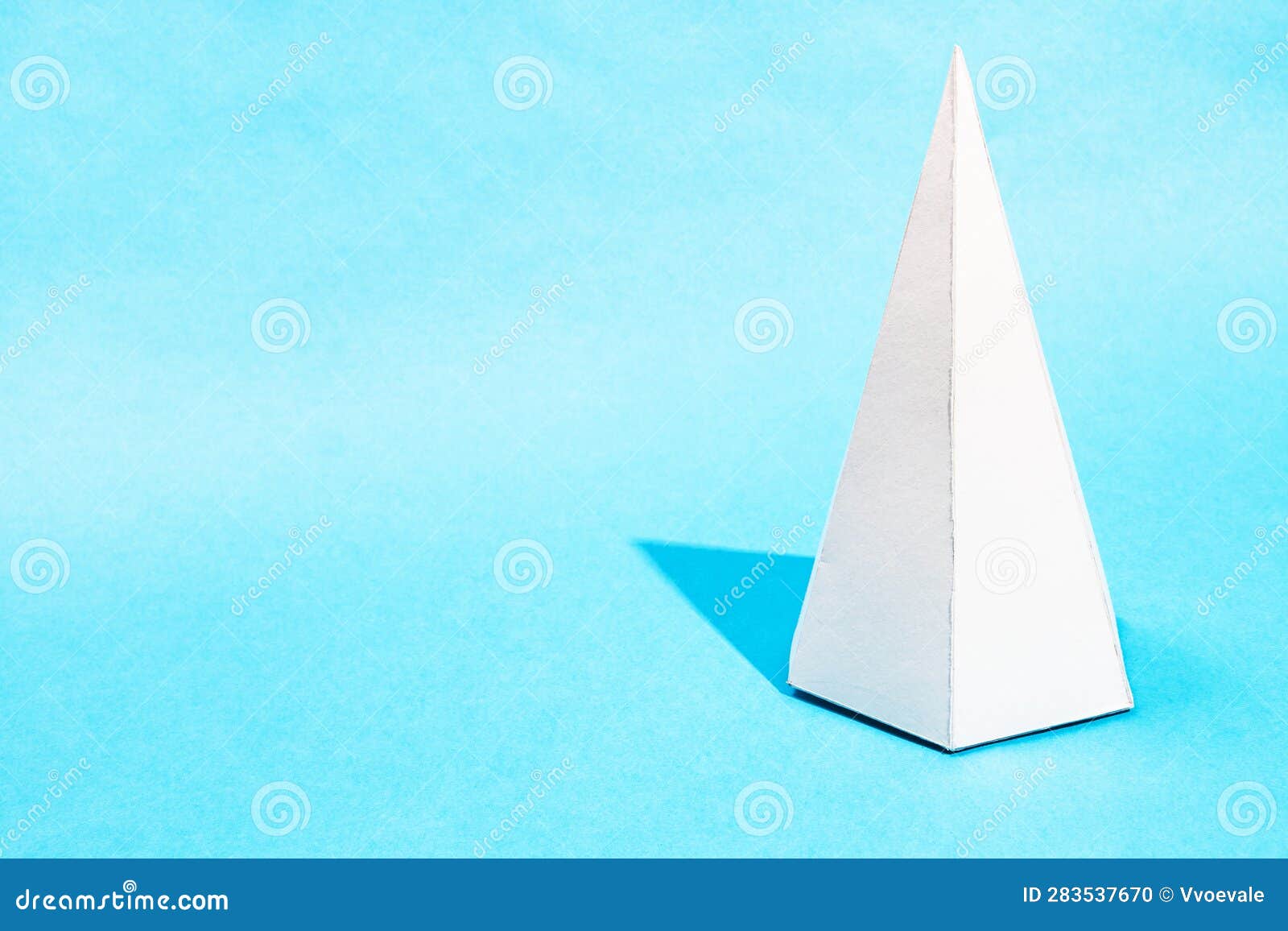 Tall Hand-crafted Paper Pyramid on Turquoise Blue Stock Photo - Image ...