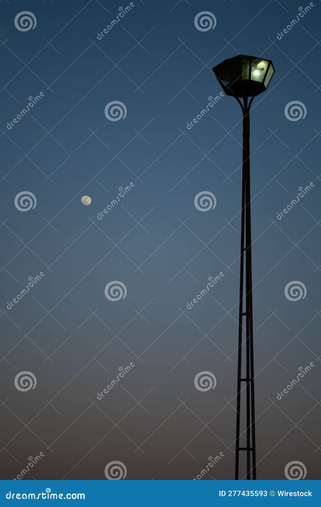A Tall Lamp Post Under a Clear Sky and the Moon Stock Image - Image of ...
