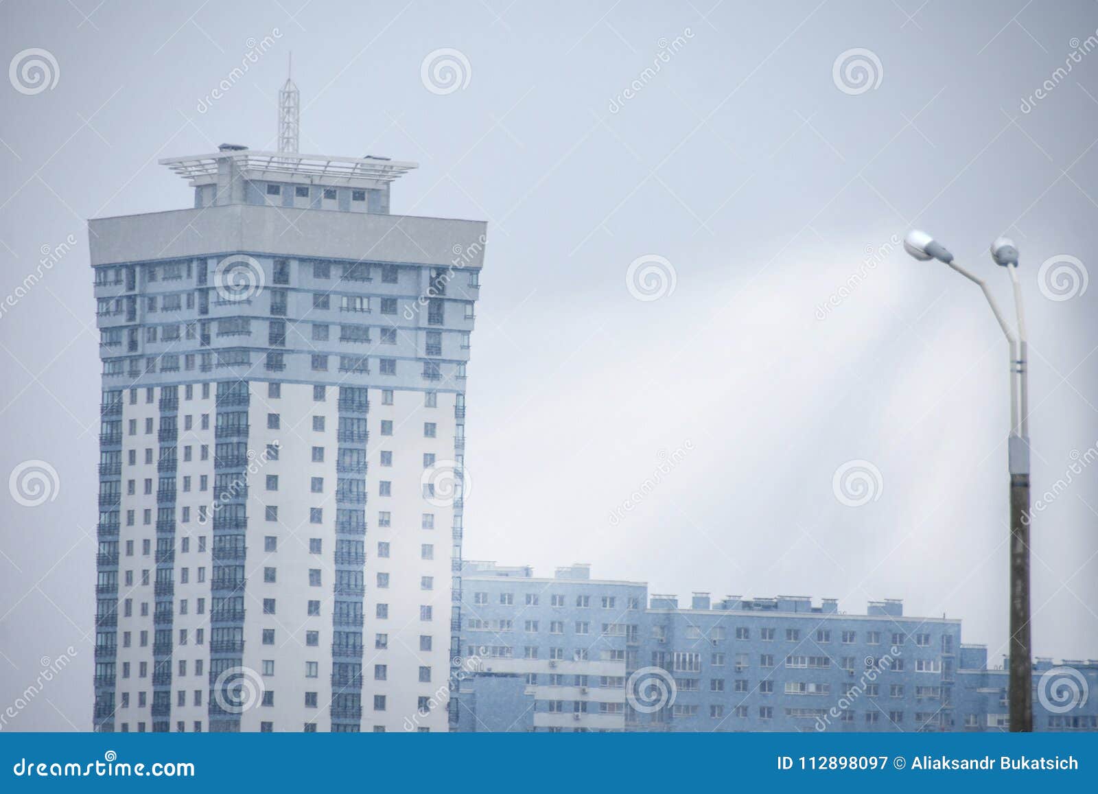 A Tall Modern Building is Illuminated by a Lantern during a Snowfall ...
