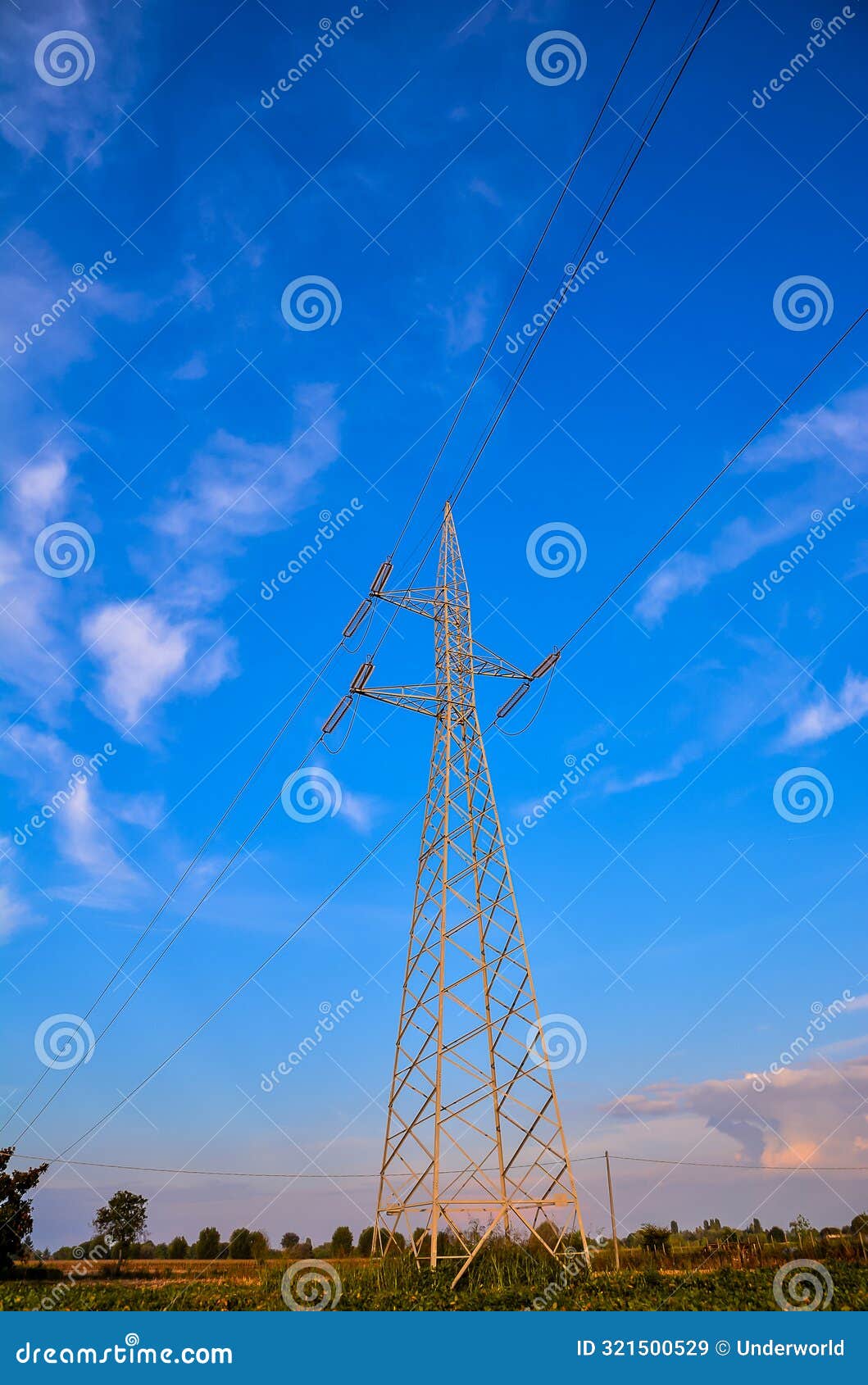 A Tall Power Tower is Standing in a Field with a Clear Blue Sky Stock ...
