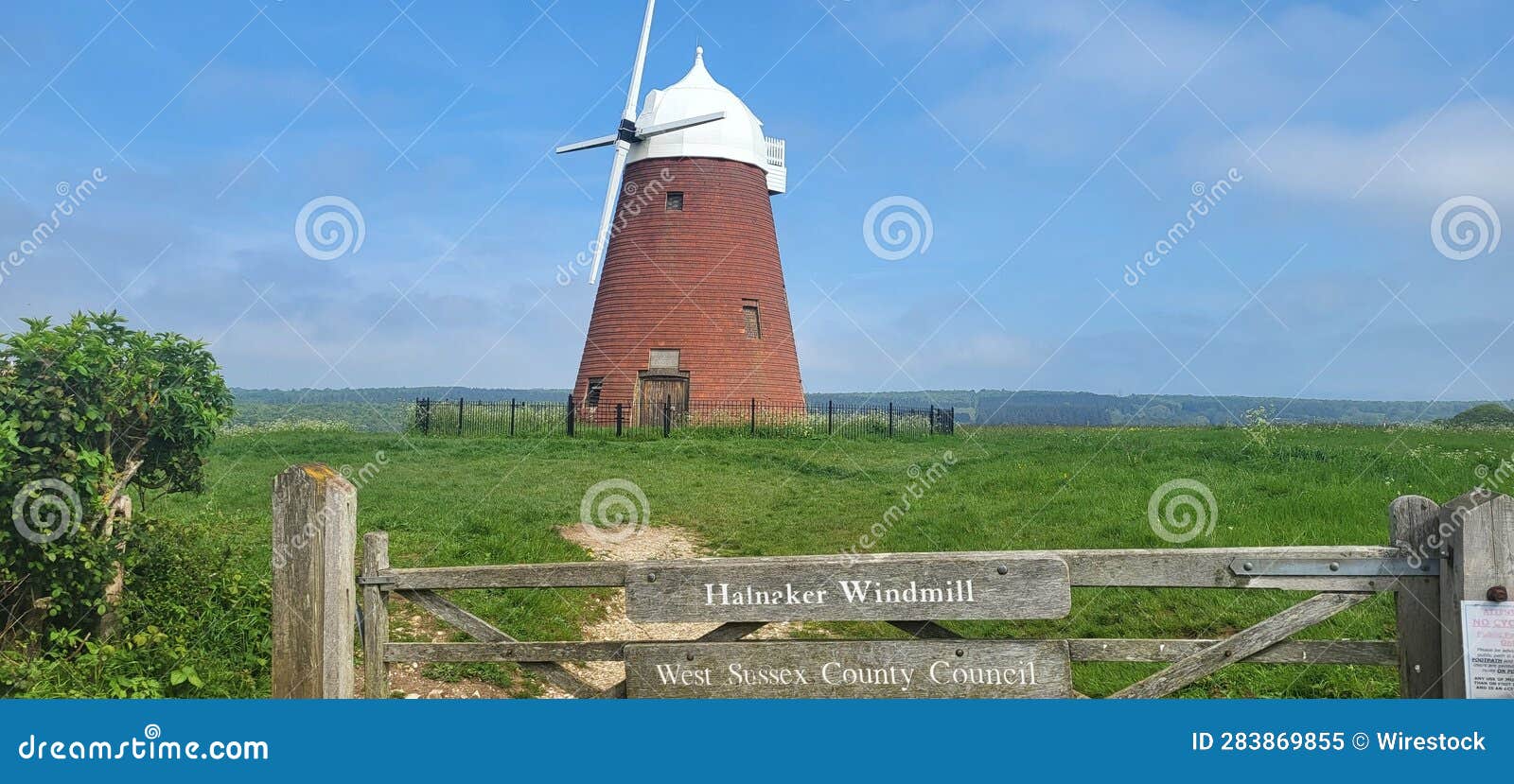 A Tall Windmill in Front of a Wooden Gate with a Marker Stock Image ...