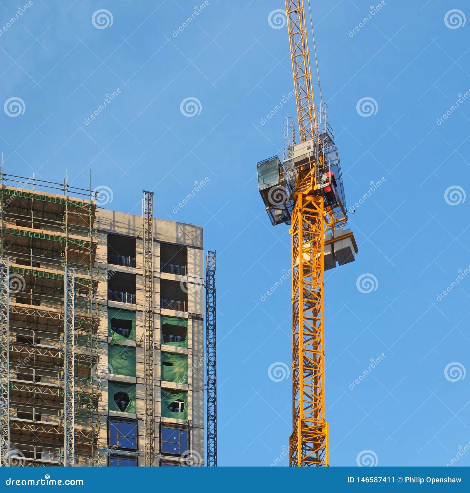 Tall Yellow Crane Working on a Large Multistory Building Under ...