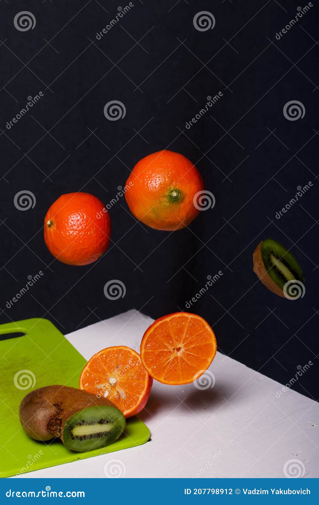 Tangerines and Kiwis Float Above the Table Surface. Some are Cut into ...