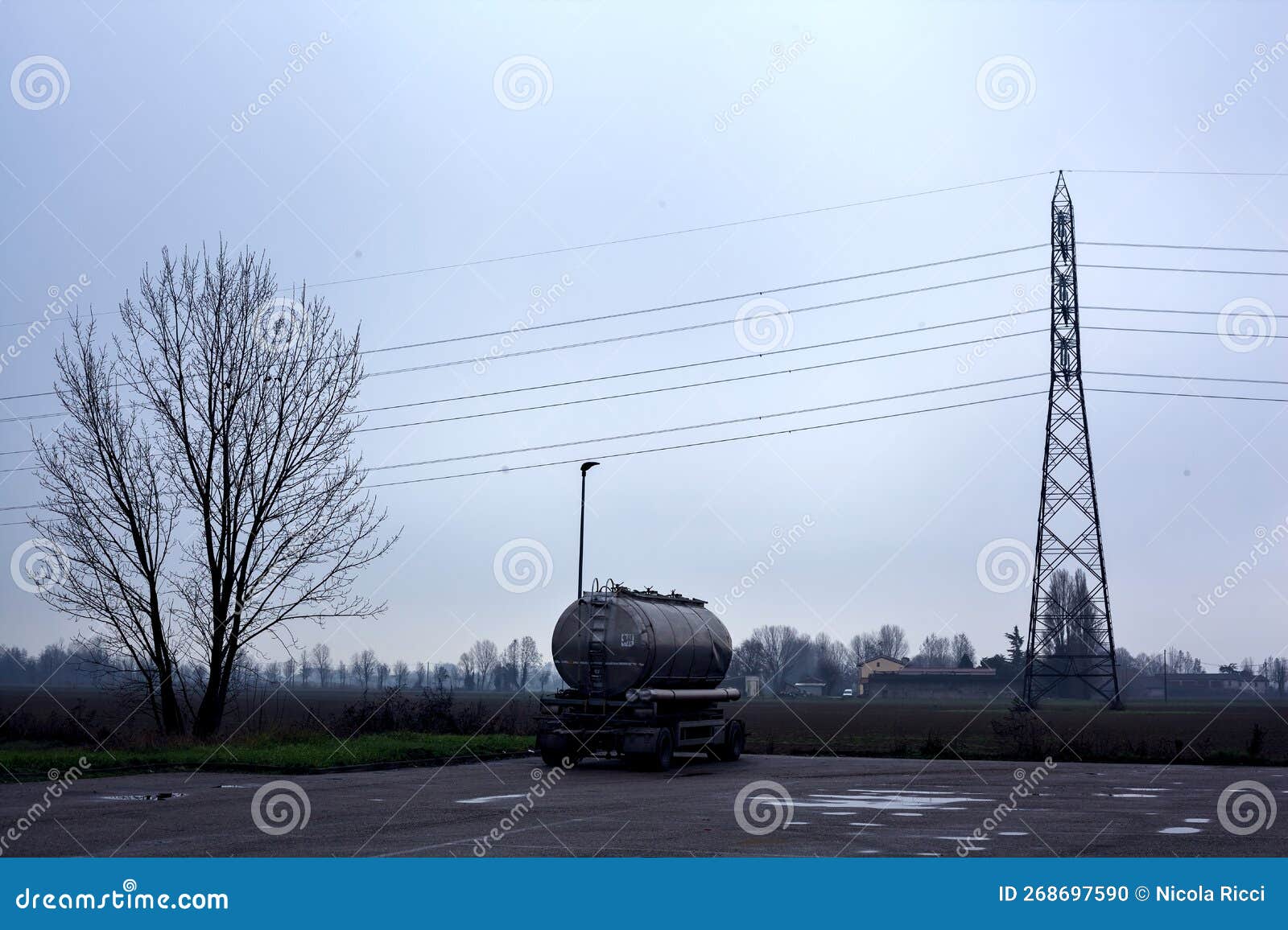 Tank in a Parking Lot by the Edge of a Fields with a Pylon on a Cloudy ...