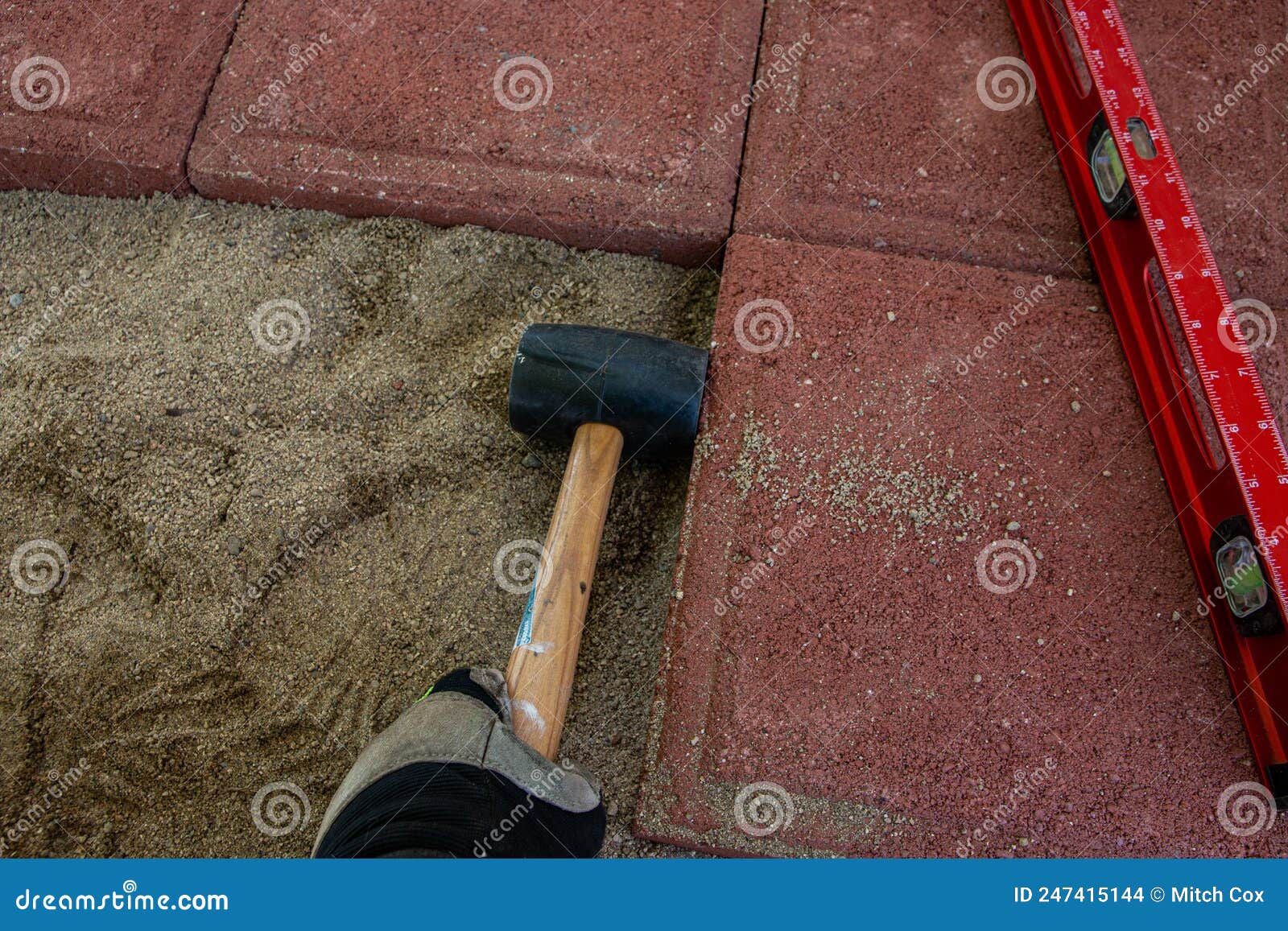 Tapping a Paving Stone stock photo. Image of paving - 247415144