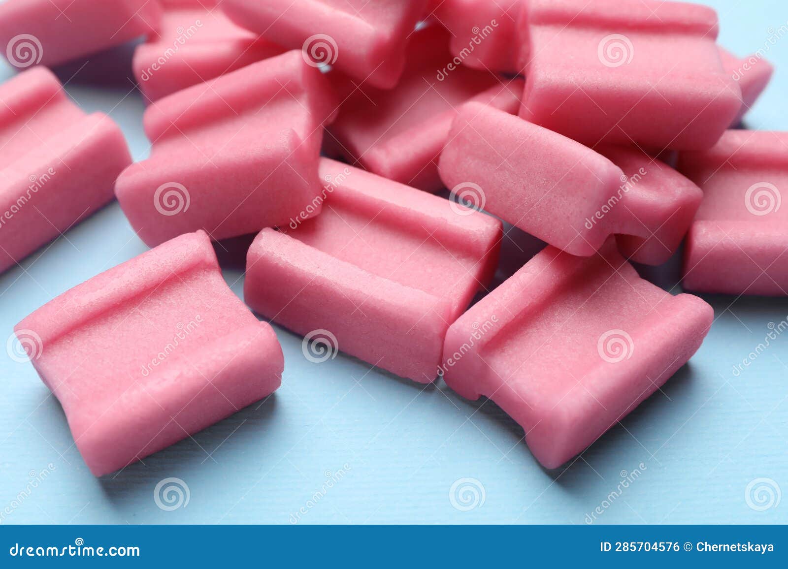 Tasty Pink Chewing Gums on Light Blue Background, Closeup Stock Photo ...