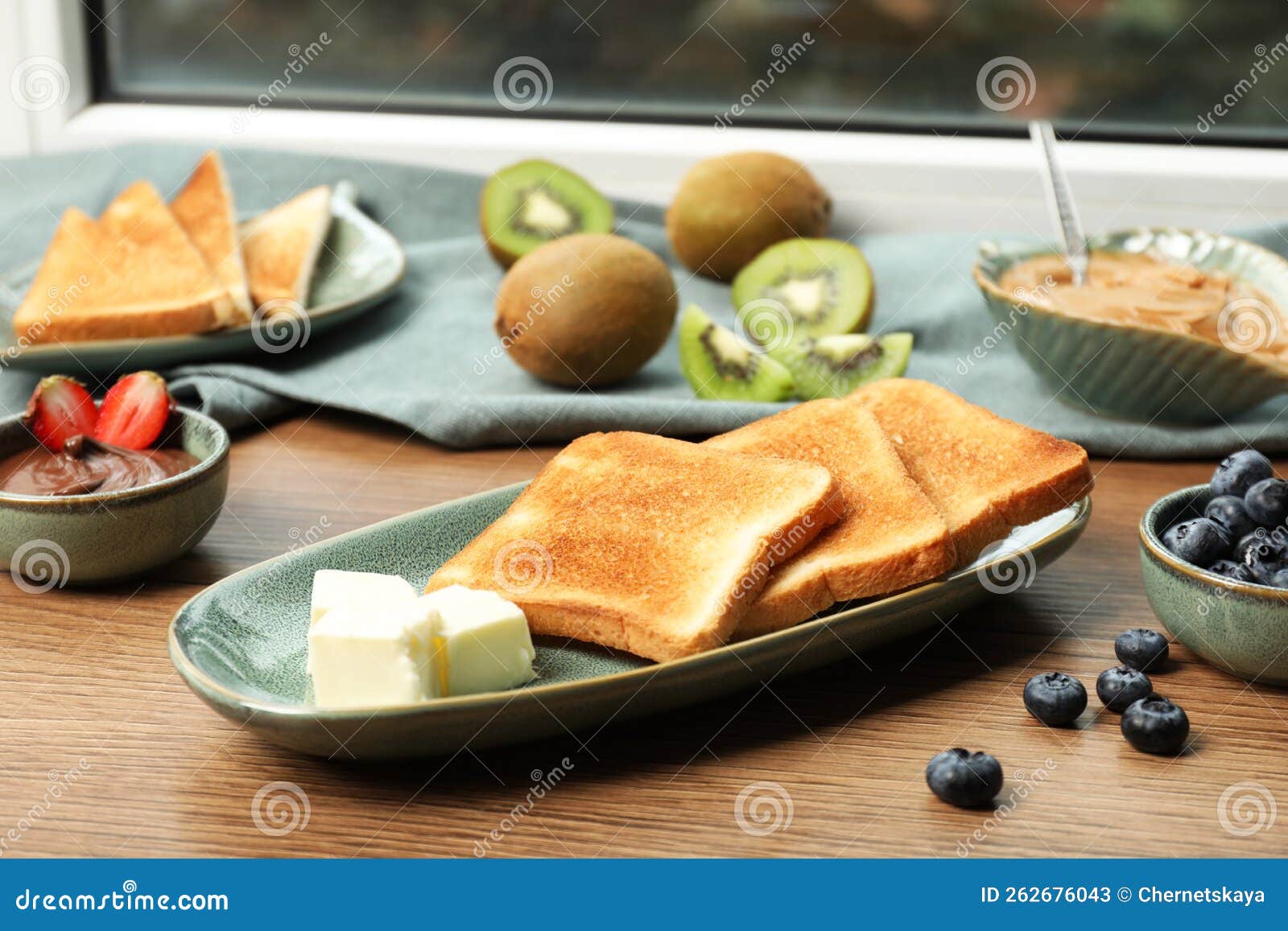 Tasty Toasts and Different Toppings on Wooden Table at Window Stock ...