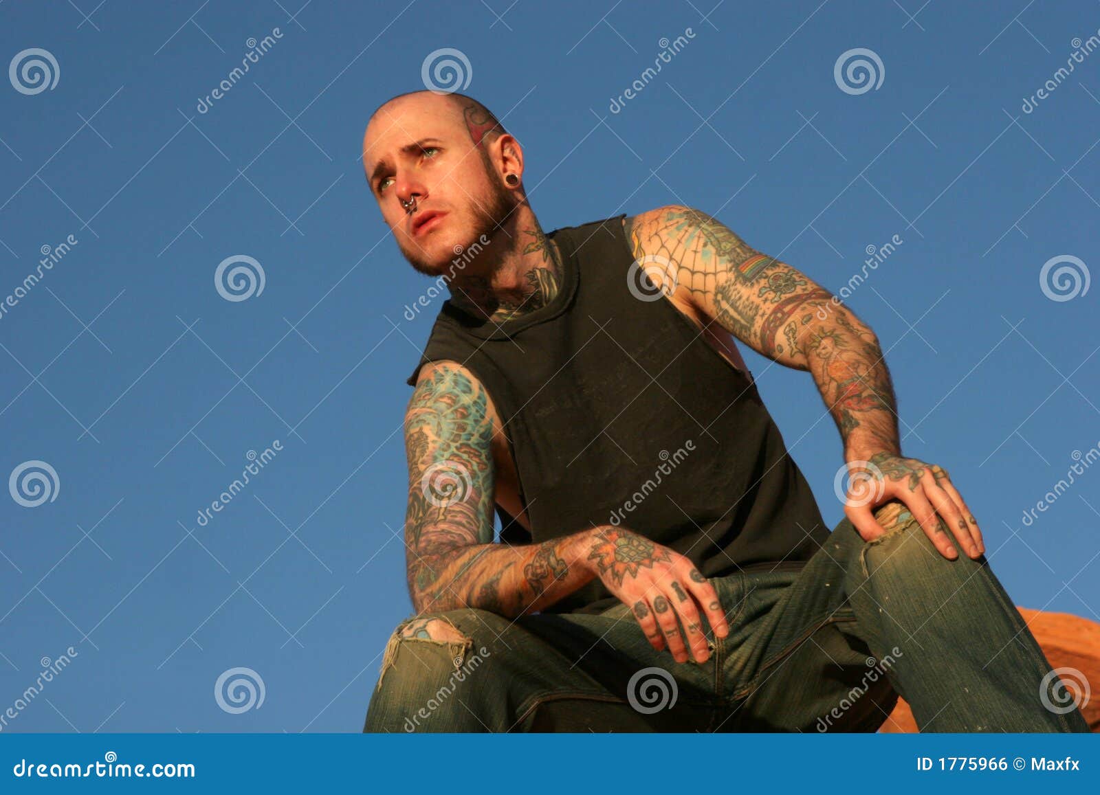 Tattooed Man Sitting on Top of Red Rocks Stock Photo - Image of ...
