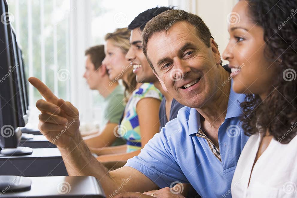 Teacher Assisting College Student on Computers Stock Image - Image of ...