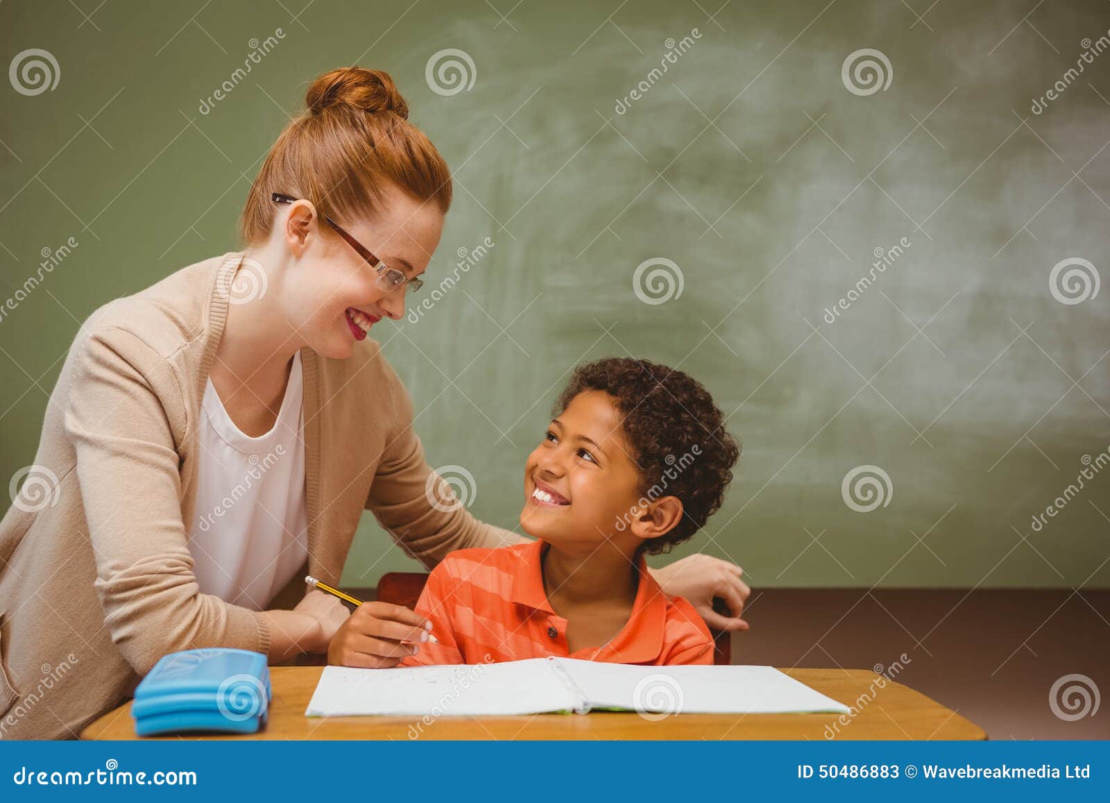 Teacher Assisting Little Boy with Homework in Classroom Stock Image ...