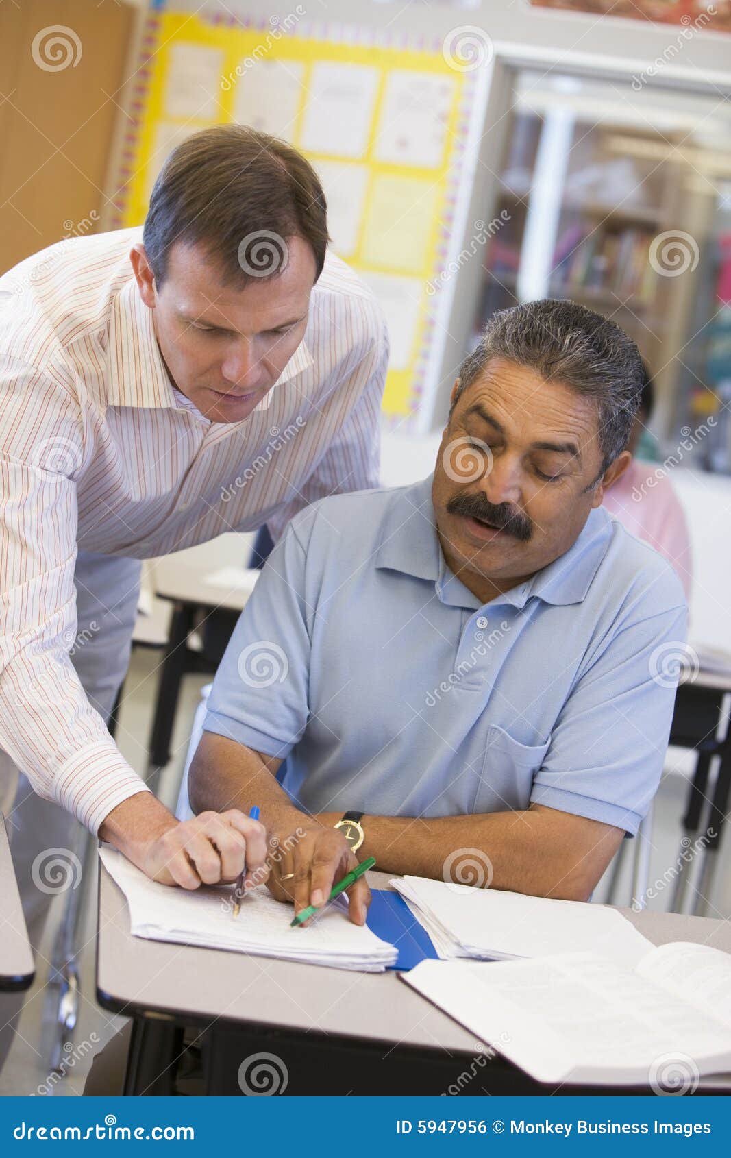 Teacher Assisting Mature Student in Class Stock Photo - Image of ...