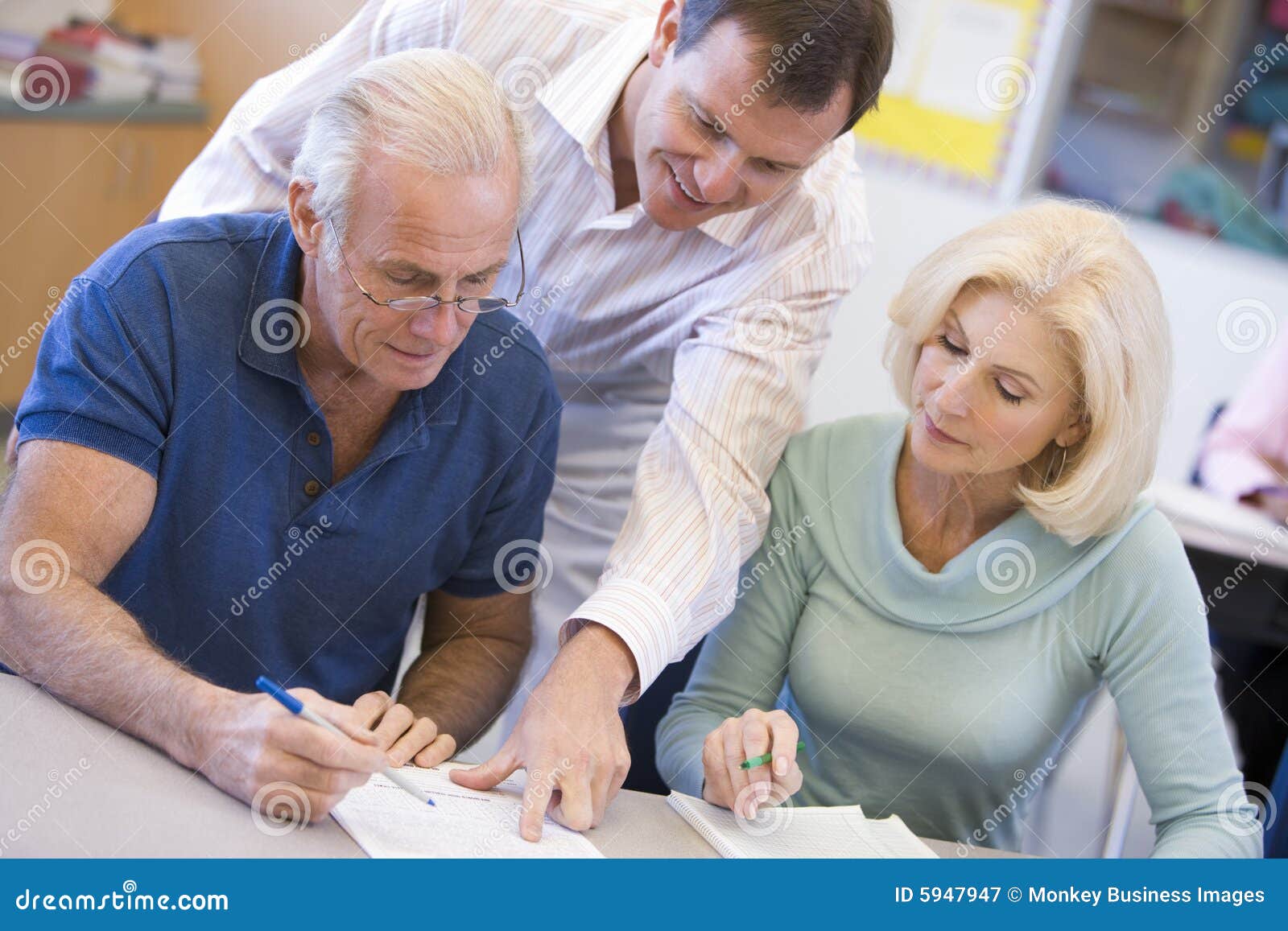 Teacher Assisting Mature Students in Class Stock Image - Image of ...