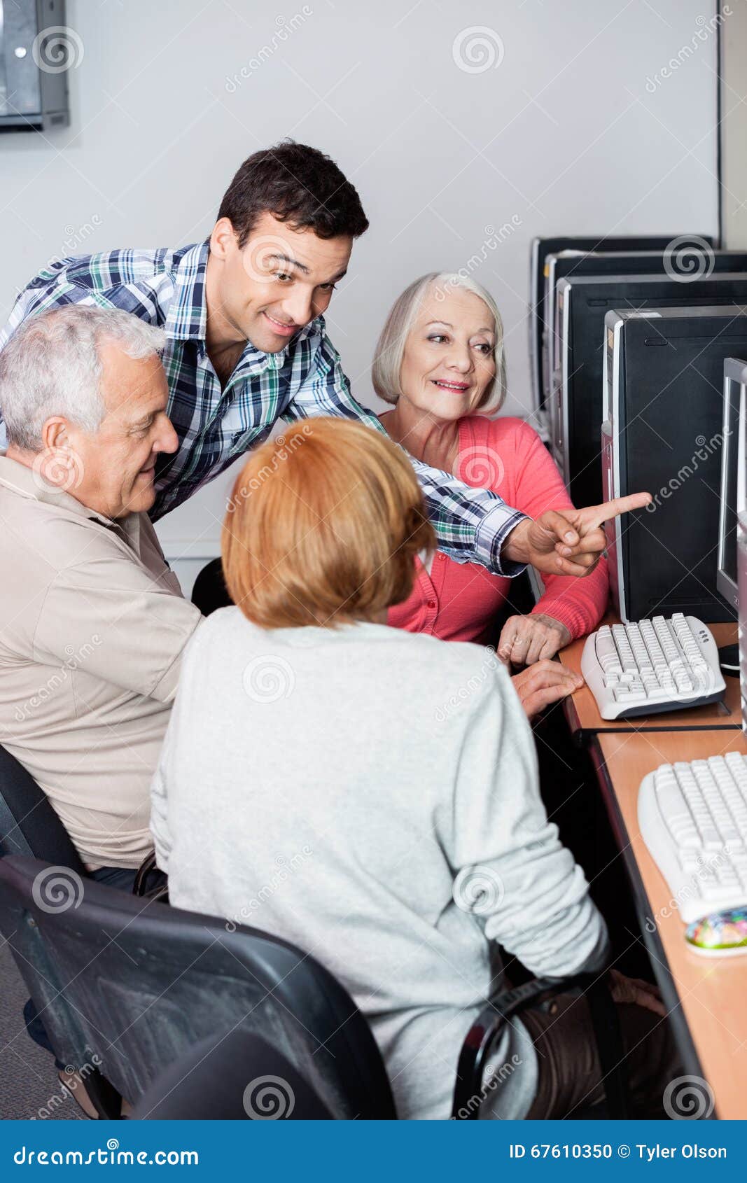 Teacher Assisting Senior People in Using Computer at Classroom Stock ...