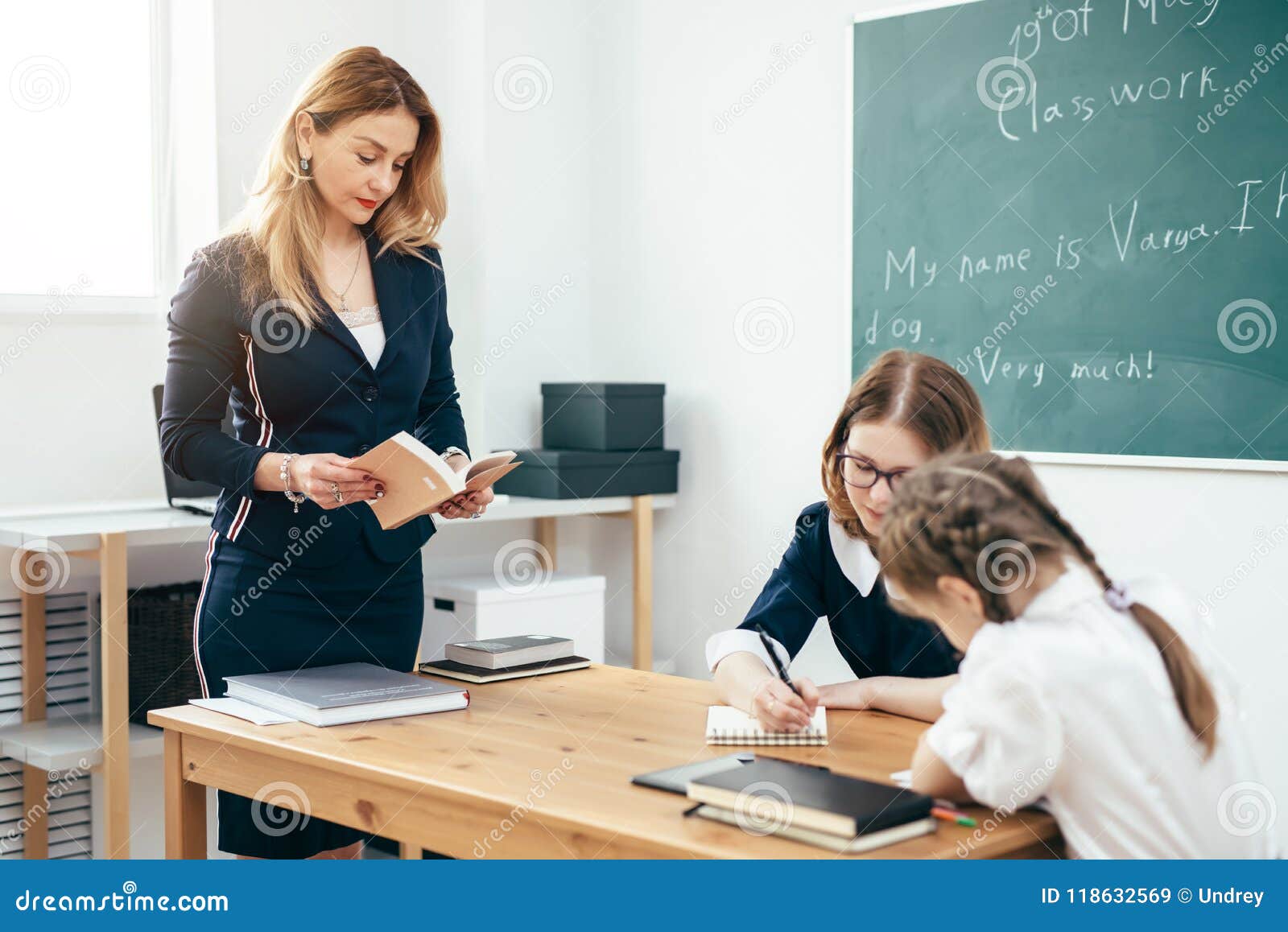 Teacher with Book Giving Lesson in Classroom. Stock Image - Image of ...