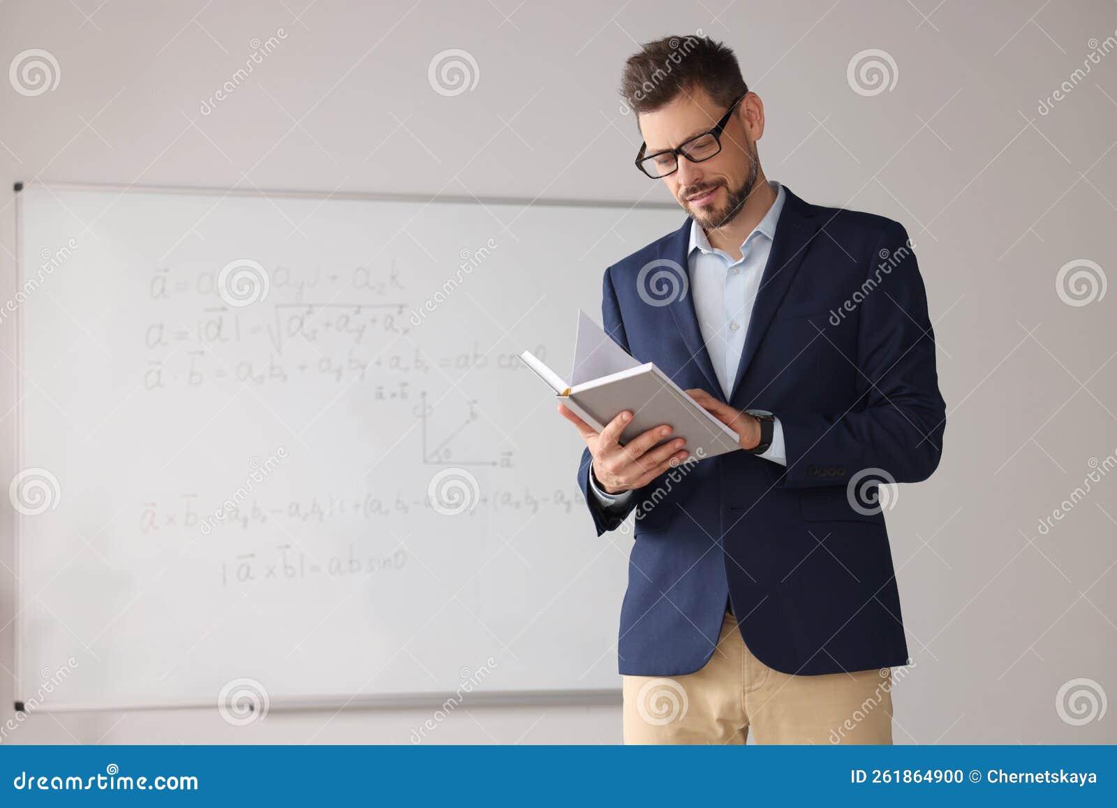 Teacher with Book at Whiteboard in Classroom during Math Lesson Stock ...