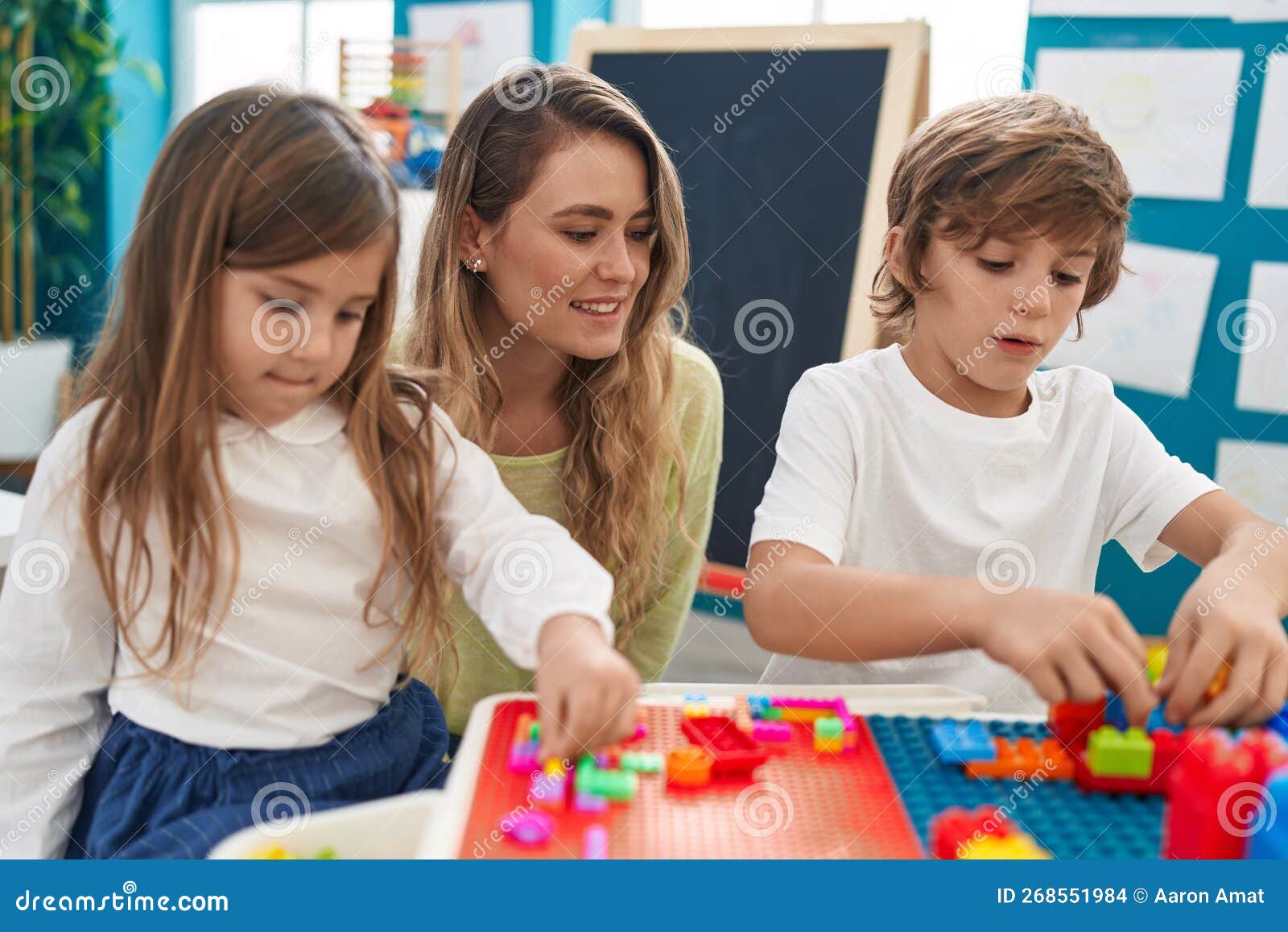 Teacher with Boy and Girl Playing with Construction Blocks Sitting on ...