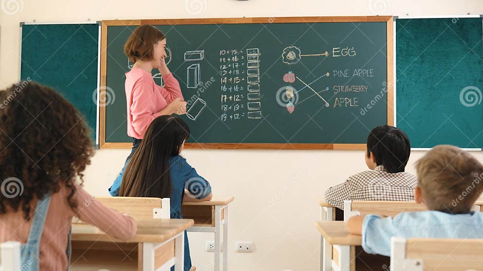 Teacher Checking Cute Student Homework while Explaining Idea at Class ...