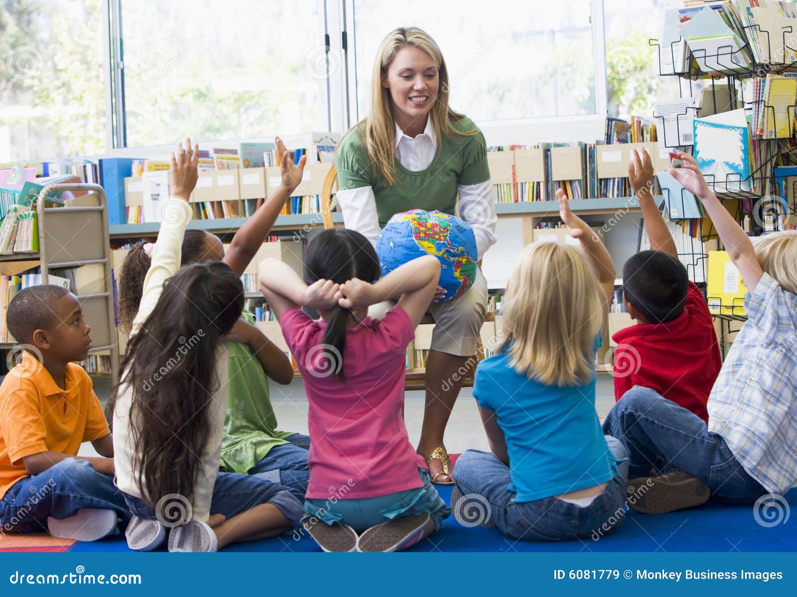 Teacher and Children with Hands Raised in Library Stock Image - Image ...