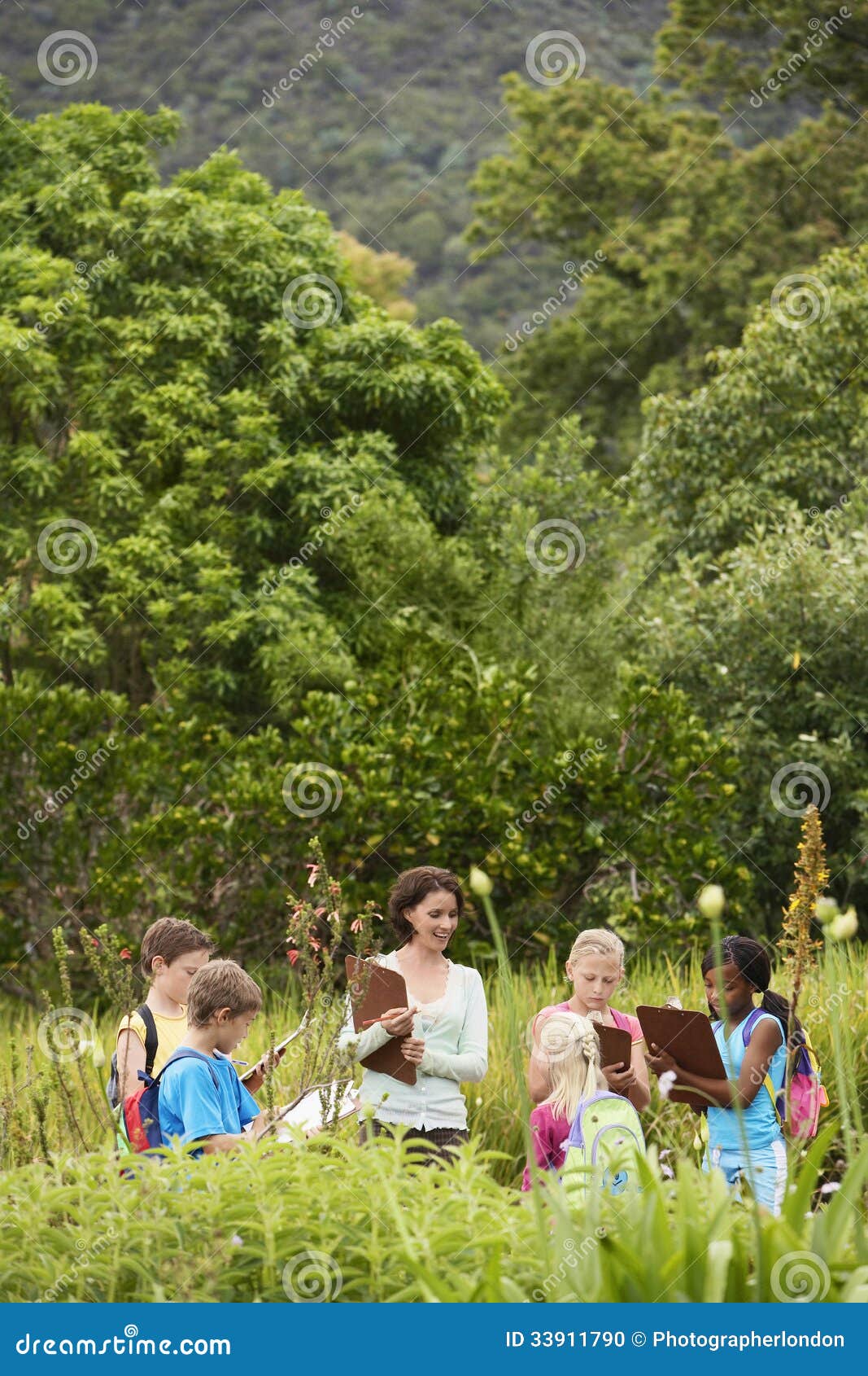 Teacher with Children Preparing Notes during Field Trip Stock Photo ...